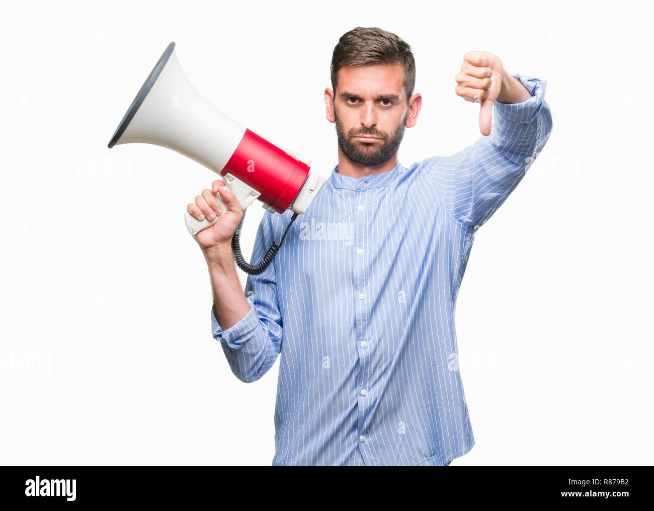 Young handsome man yelling through megaphone over isolated background ...