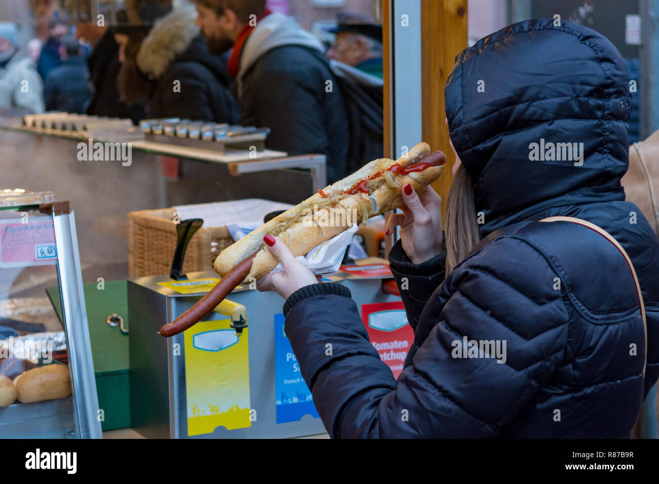 Hungry person eating ridiculously long hot dog at outdoor stand Stock ...