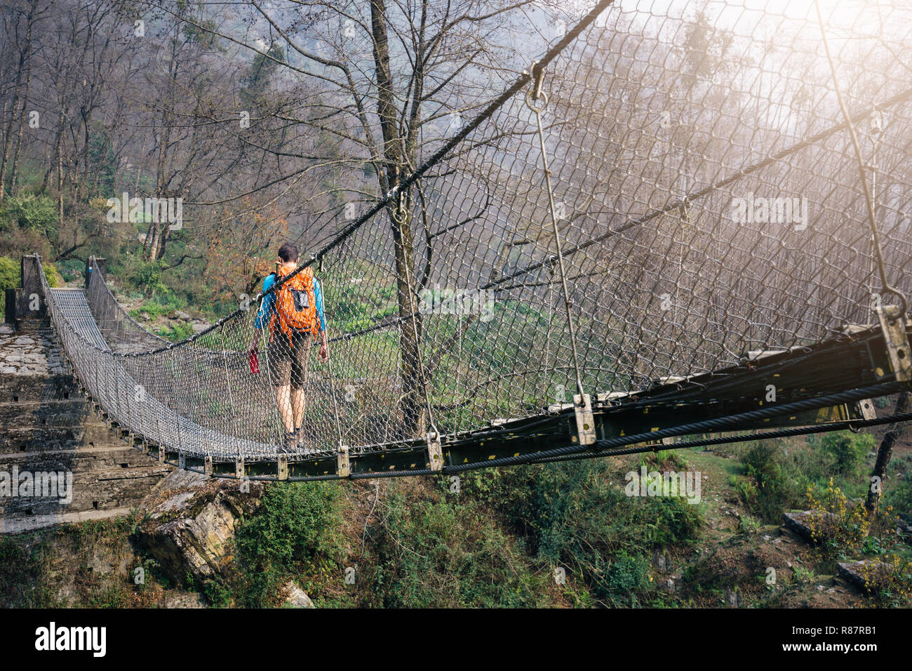 Backpacker crossing suspension bridge hi-res stock photography and ...