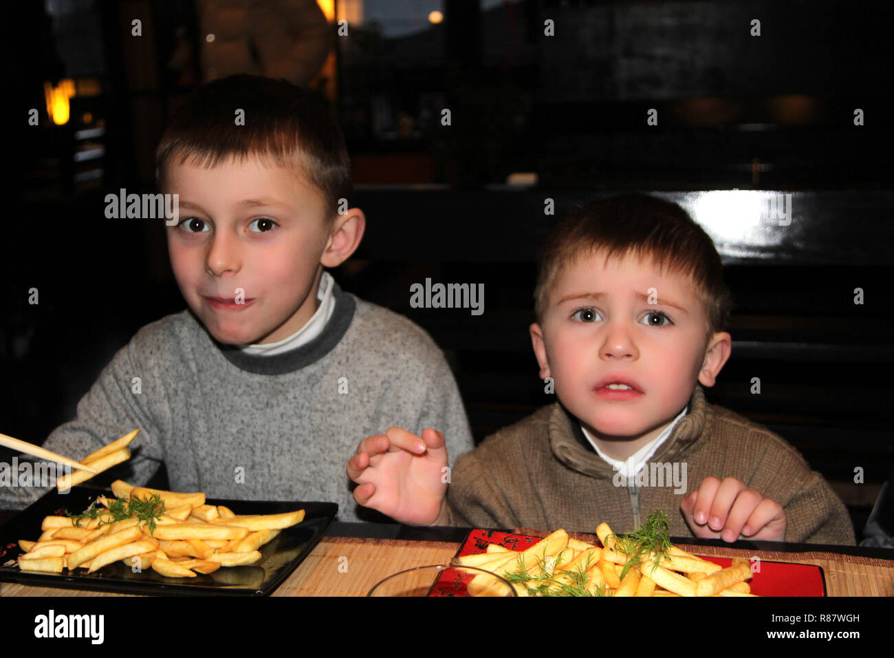 Boy eating French fries in a street cafe Stock Photo - Alamy