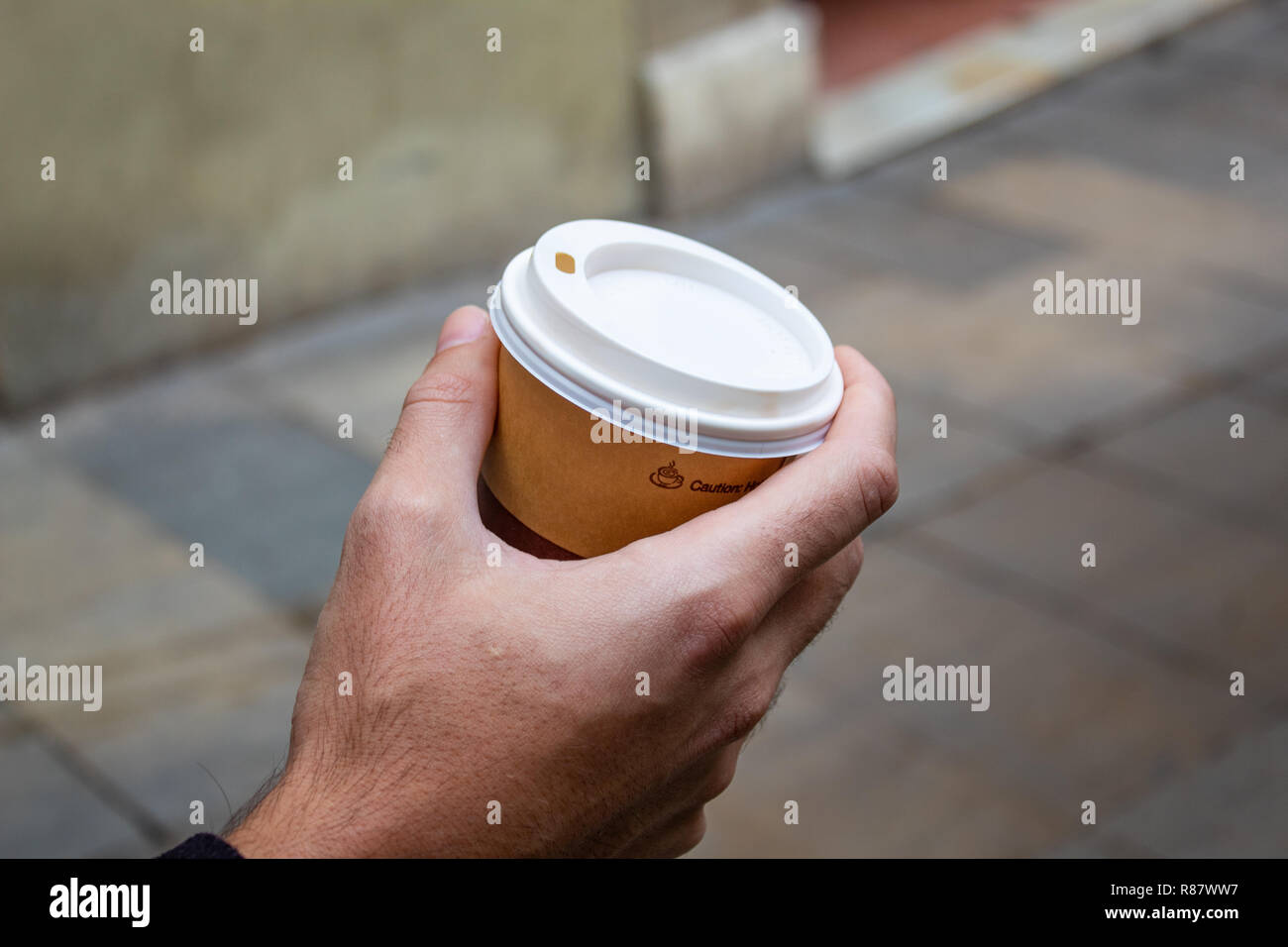 Male hand holding cup of coffee to go Stock Photo - Alamy