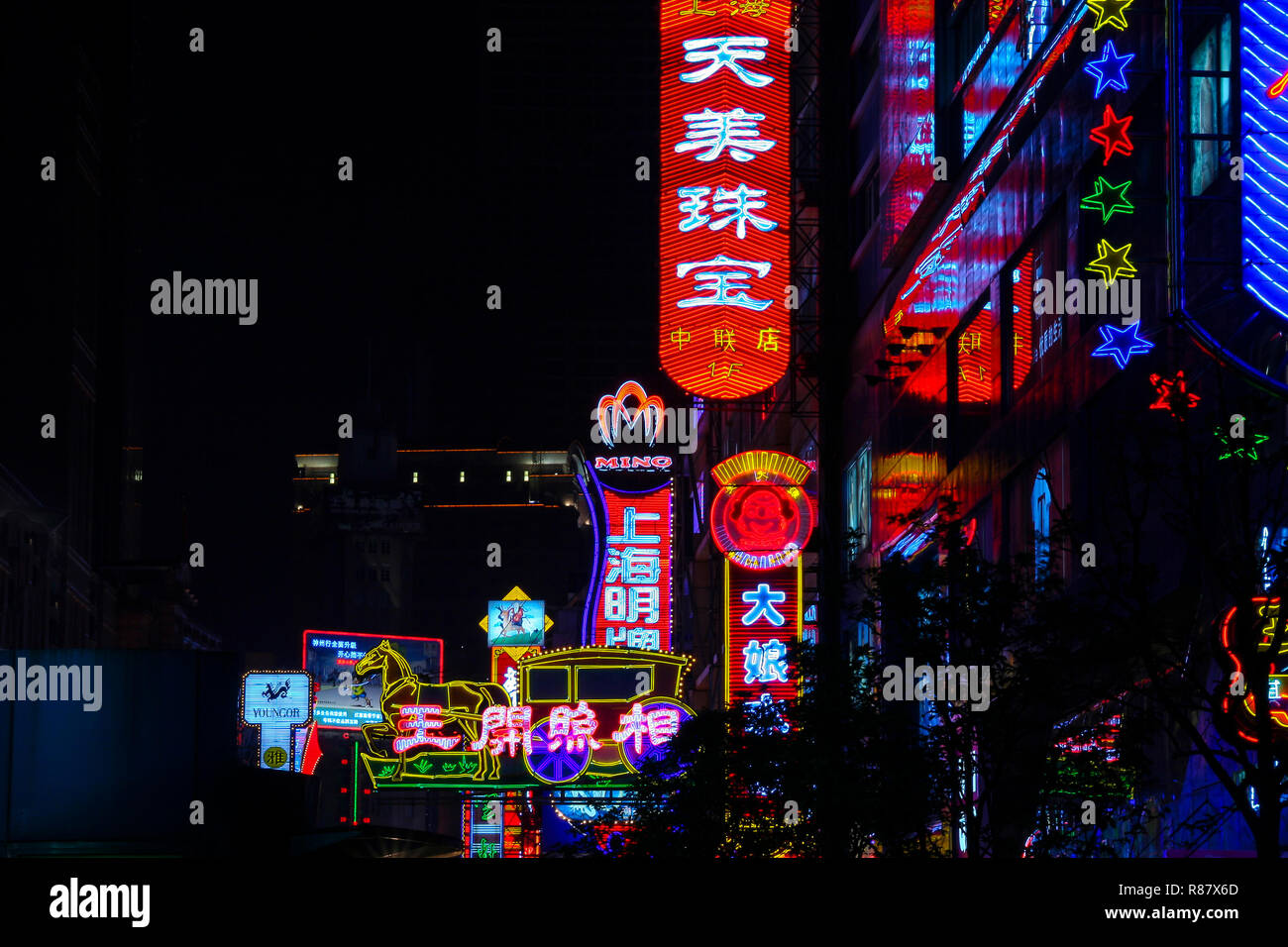 City street illuminated by neon lights and signs in all colors ...