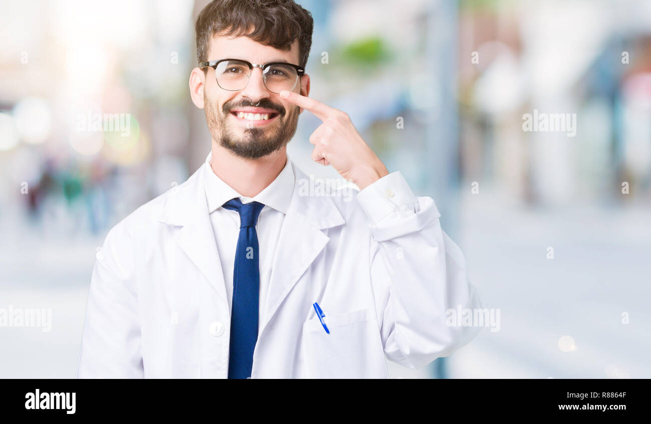 Young professional scientist man wearing white coat over isolated ...