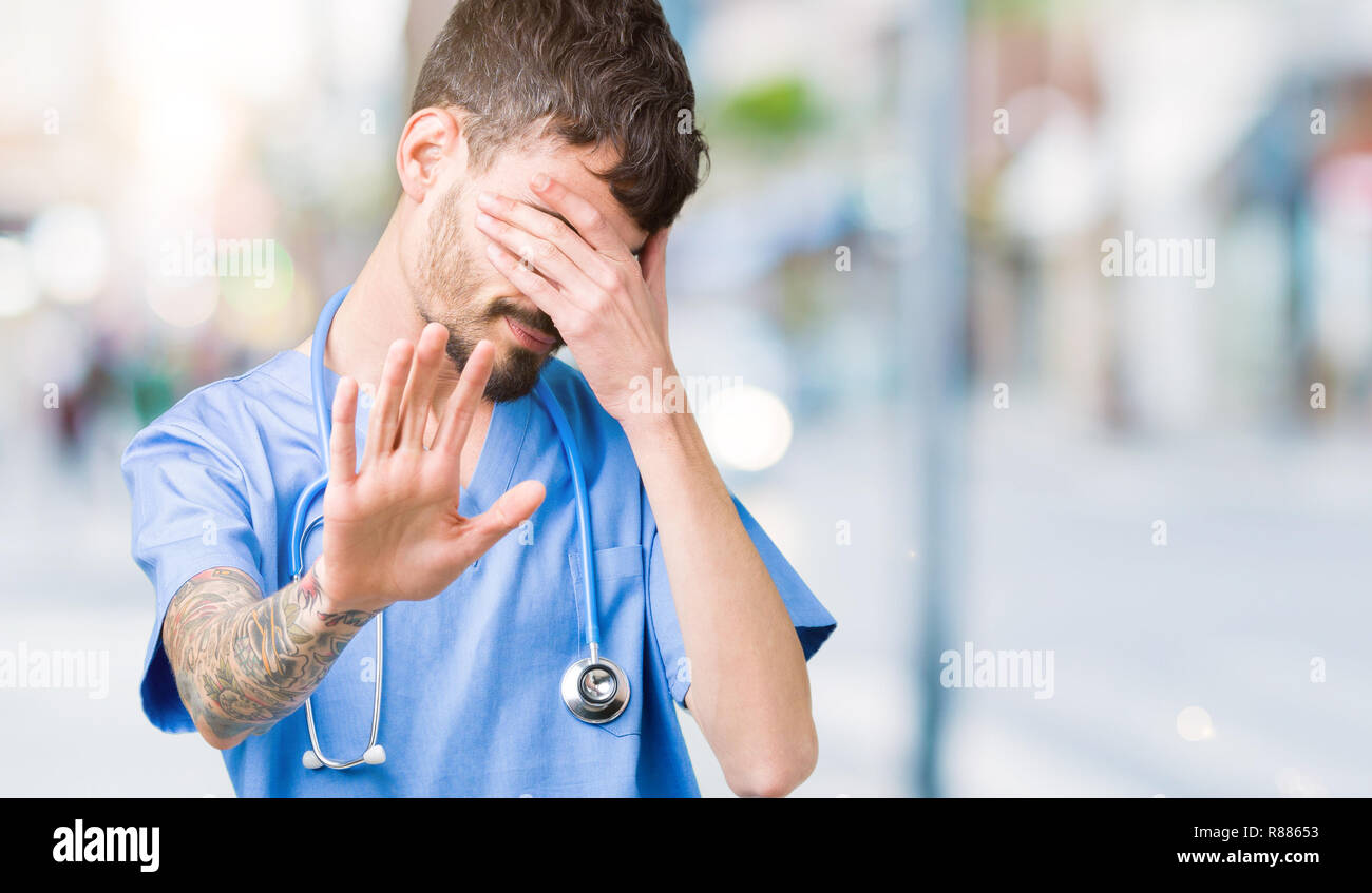 Young handsome nurse man wearing surgeon uniform over isolated ...