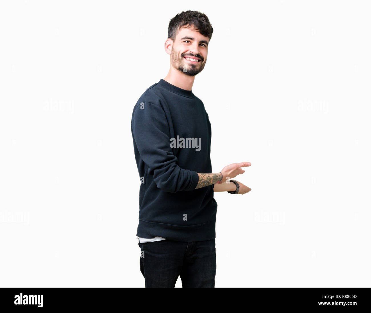 Young handsome man over isolated background Inviting to enter smiling ...