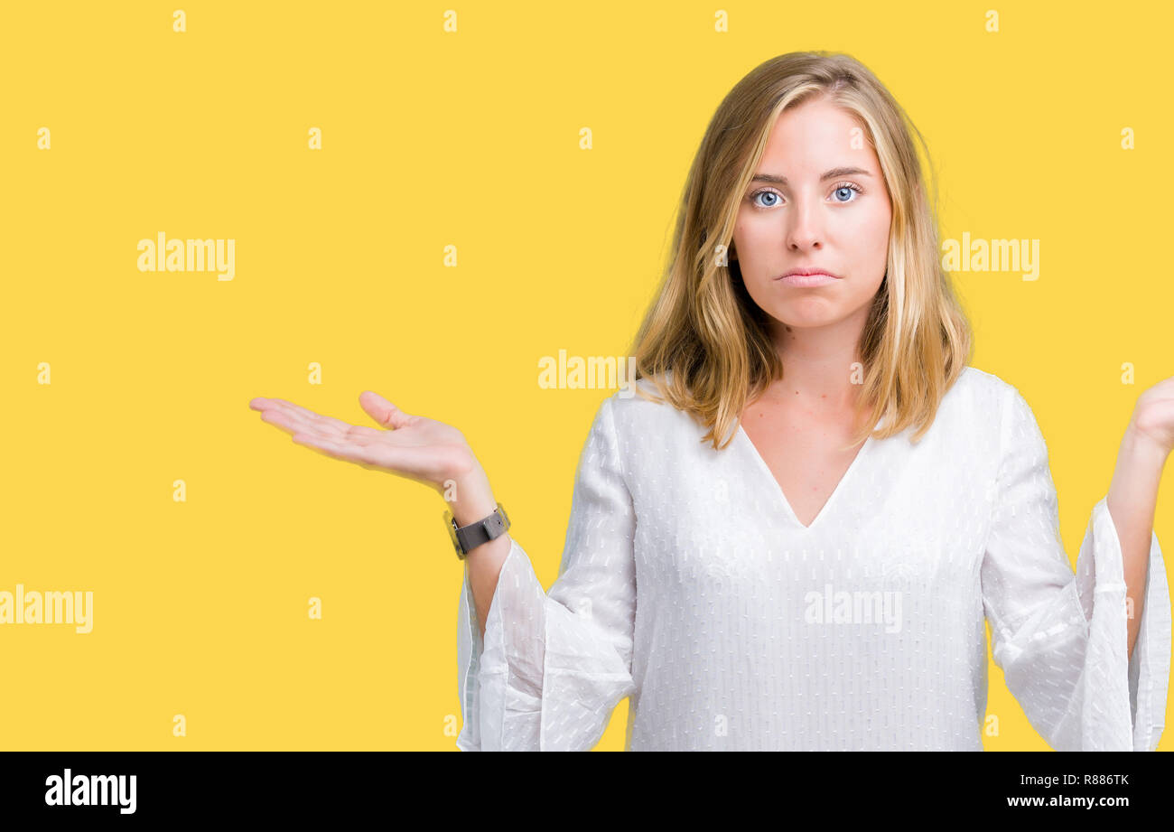 Beautiful young elegant woman over isolated background clueless and ...