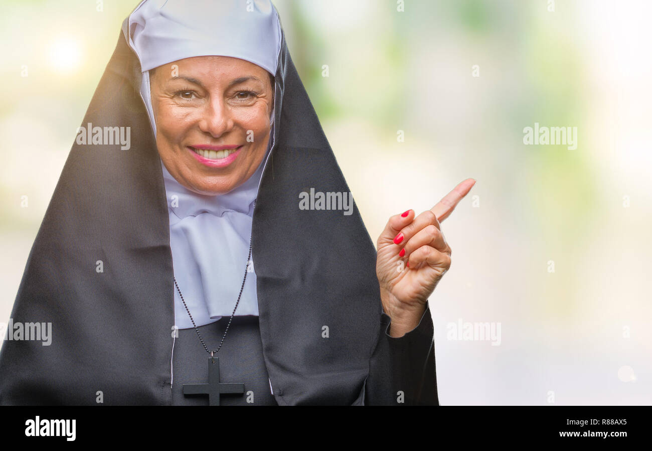 Middle age senior christian catholic nun woman over isolated background ...