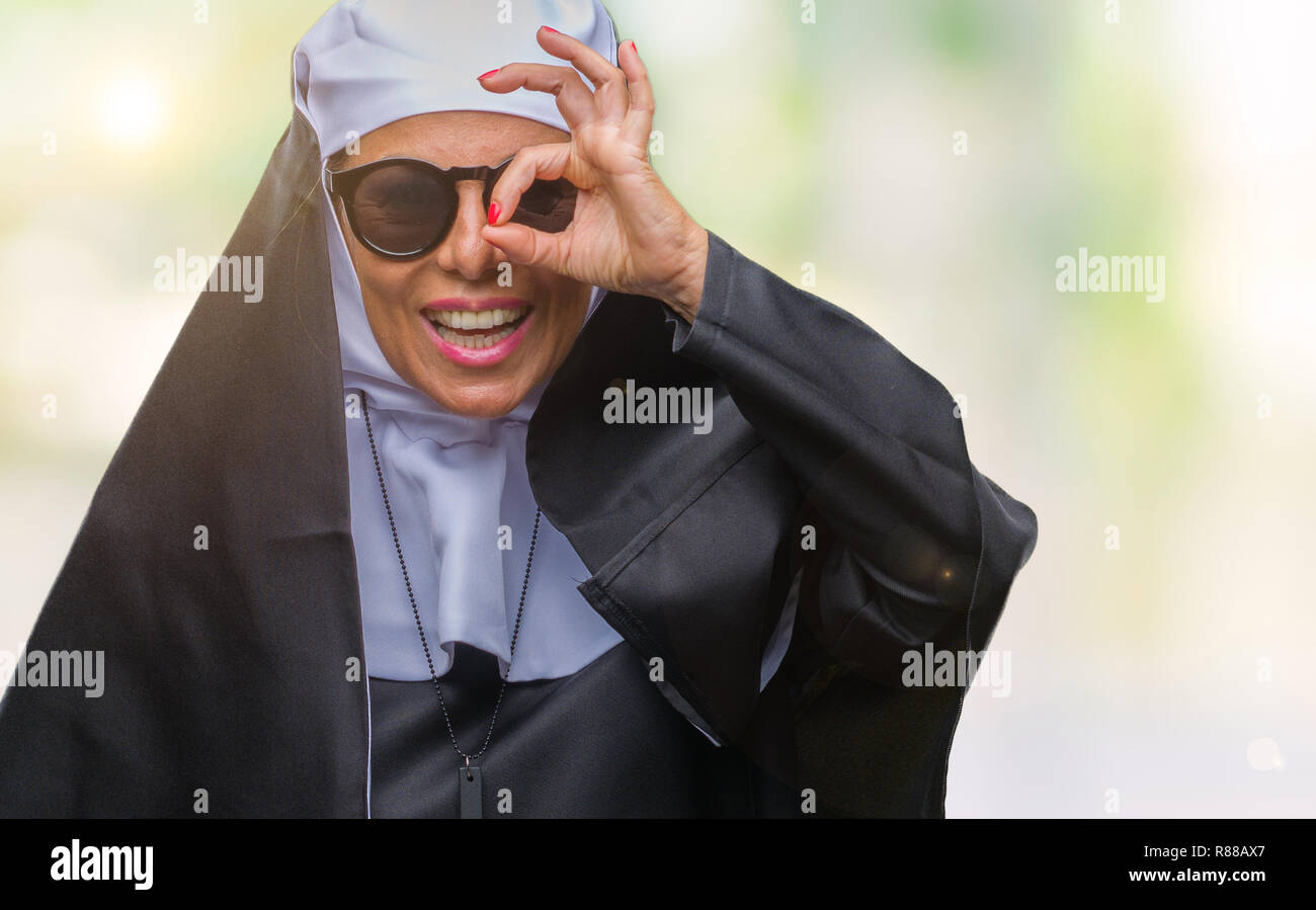 Middle age senior catholic nun woman wearing sunglasses over isolated ...