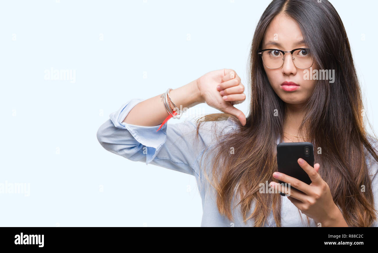 Young asian woman texting using smartphone over isolated background ...