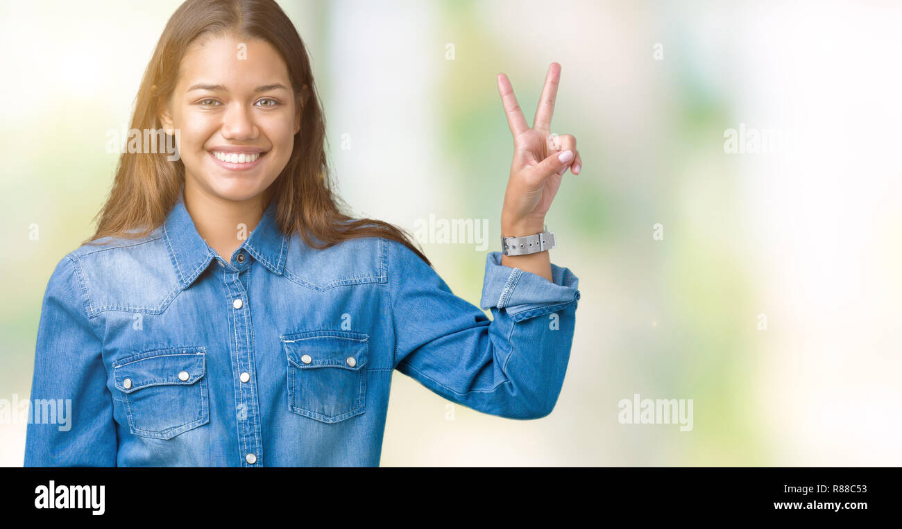 Young beautiful brunette woman wearing blue denim shirt over isolated ...