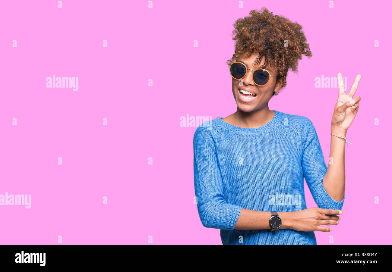 Beautiful young african american woman wearing sunglasses over isolated ...