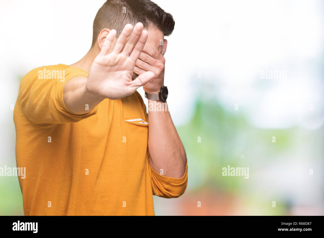 Young handsome man over isolated background covering eyes with hands ...