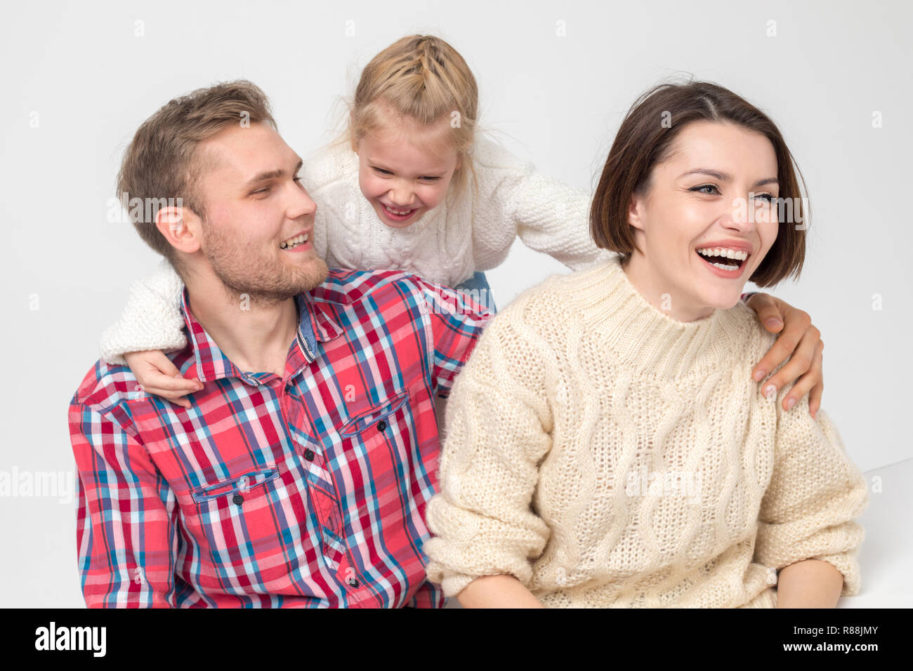 Happy family of three hugging on white background Stock Photo - Alamy