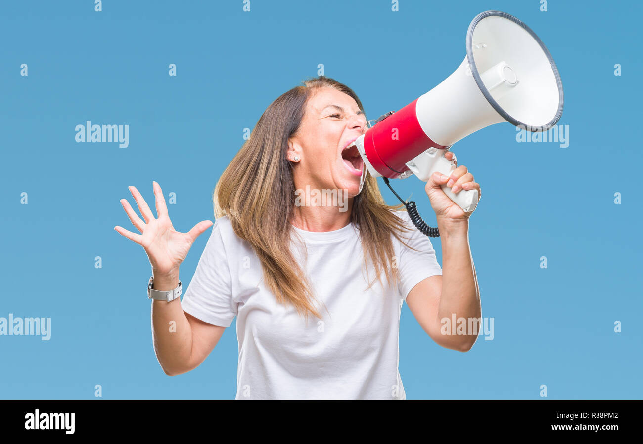 Middle age hispanic woman yelling through megaphone over isolated ...