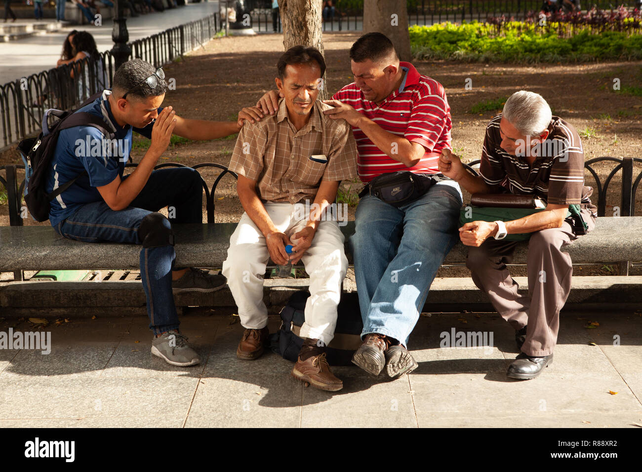 Faith healers praying and tending man in Bolivar Square, Caracas ...