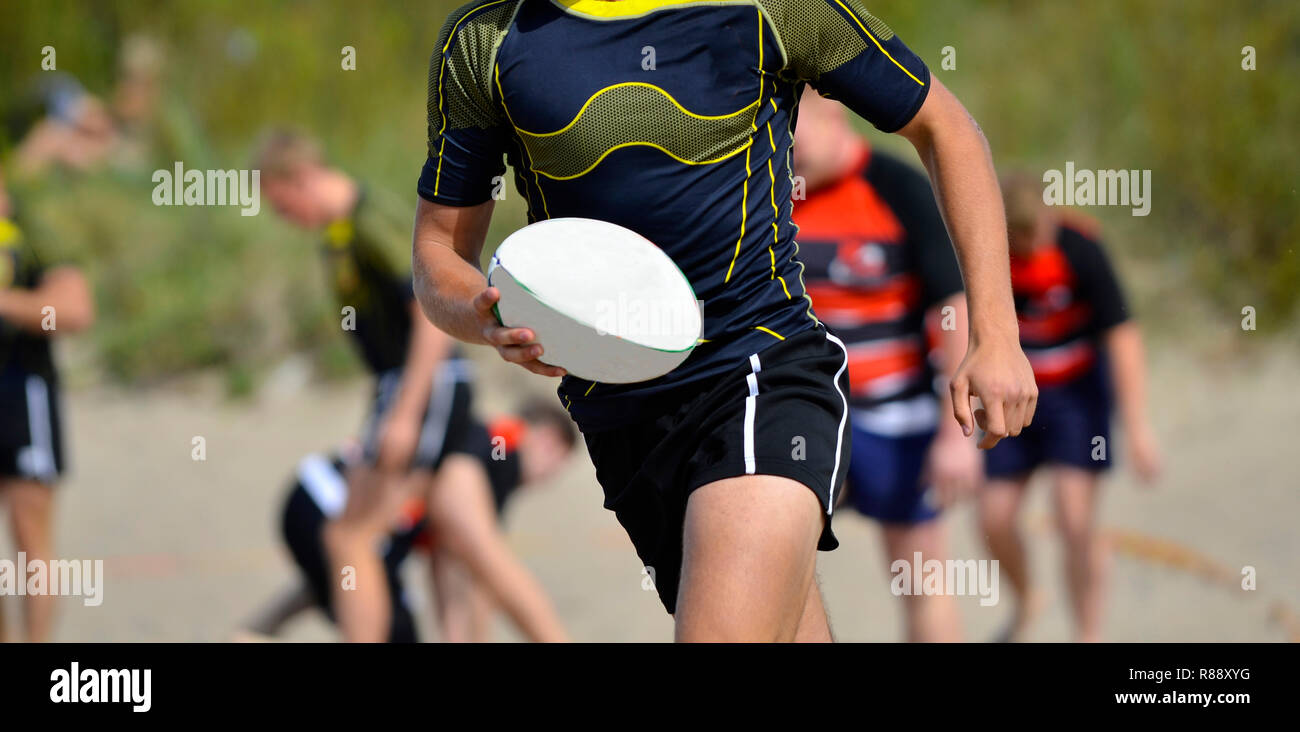 Playing rugby at the beach. Team sport Stock Photo - Alamy