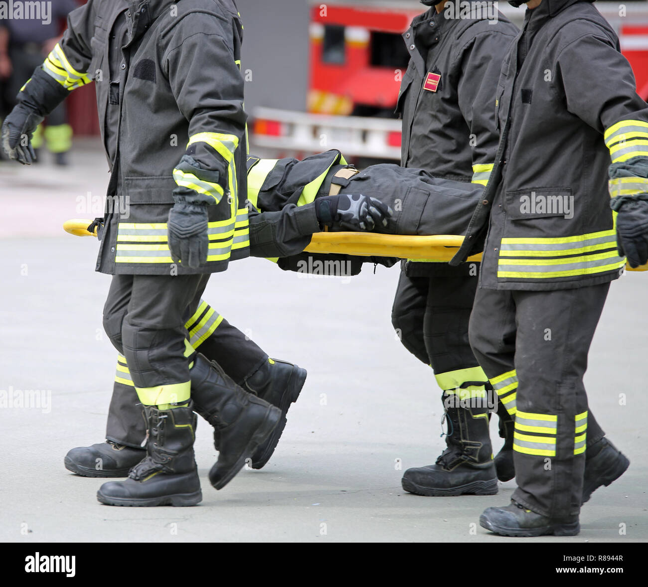 Firefighters carry a wounded man on a stretcher during an exercise ...