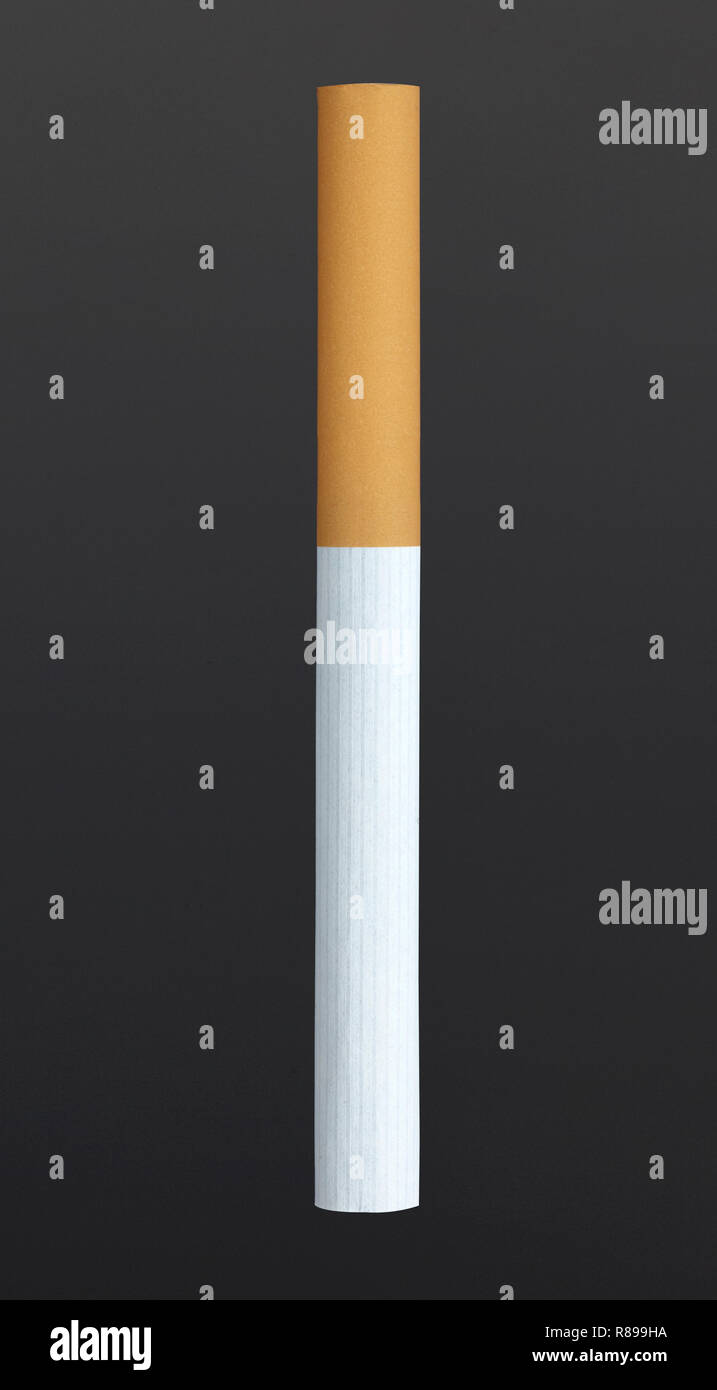 Single cigarette on dark background Stock Photo - Alamy