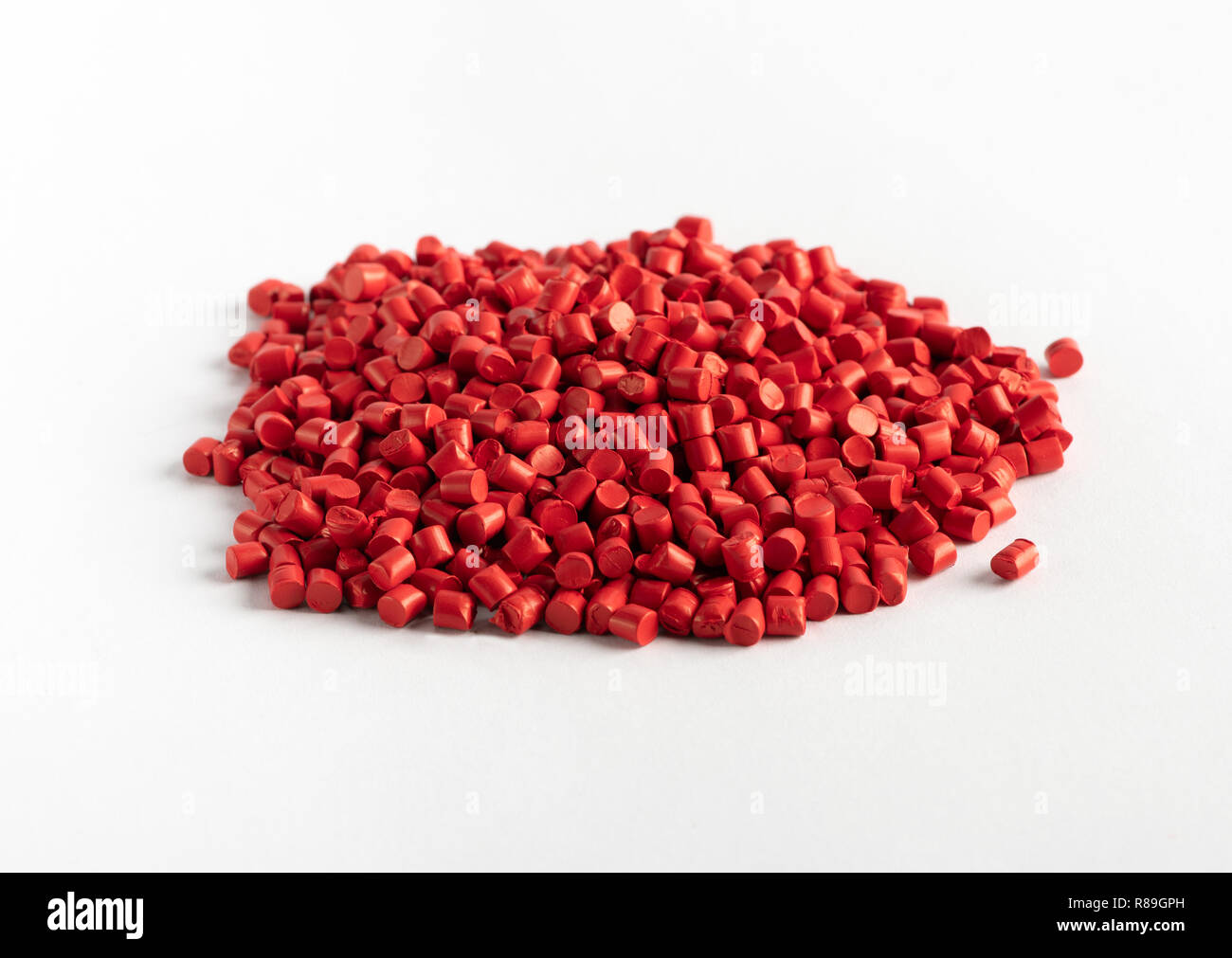 Pile of red plastic granules isolated on white background, viewed in ...