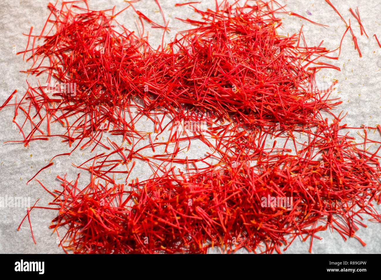 Two piles of red saffron threads viewed from above on grey kitchen ...