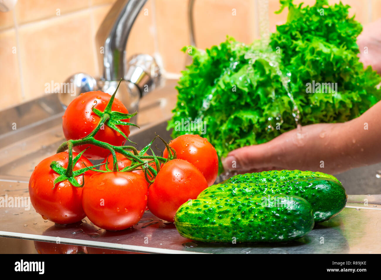 fresh clean washed vegetables on the background of a kitchen tap with ...