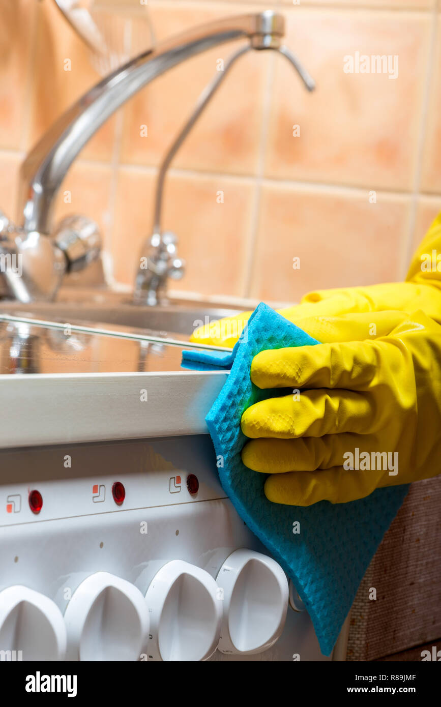 cleaning the kitchen - cleaning the stove, hands with a rag close-up ...