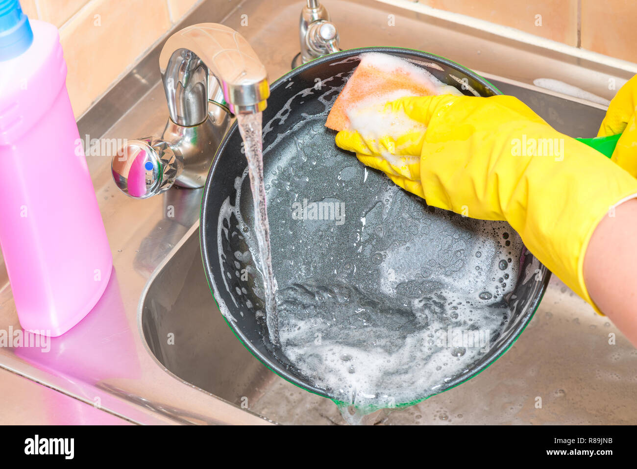 Wash the pan with foam sponge in the kitchen Stock Photo - Alamy