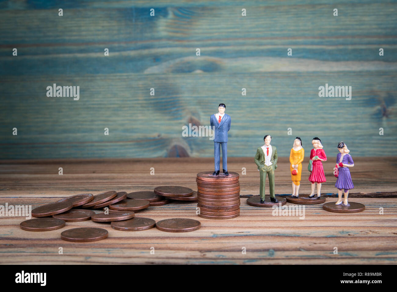 Miniature people standing on piles of coins Stock Photo - Alamy