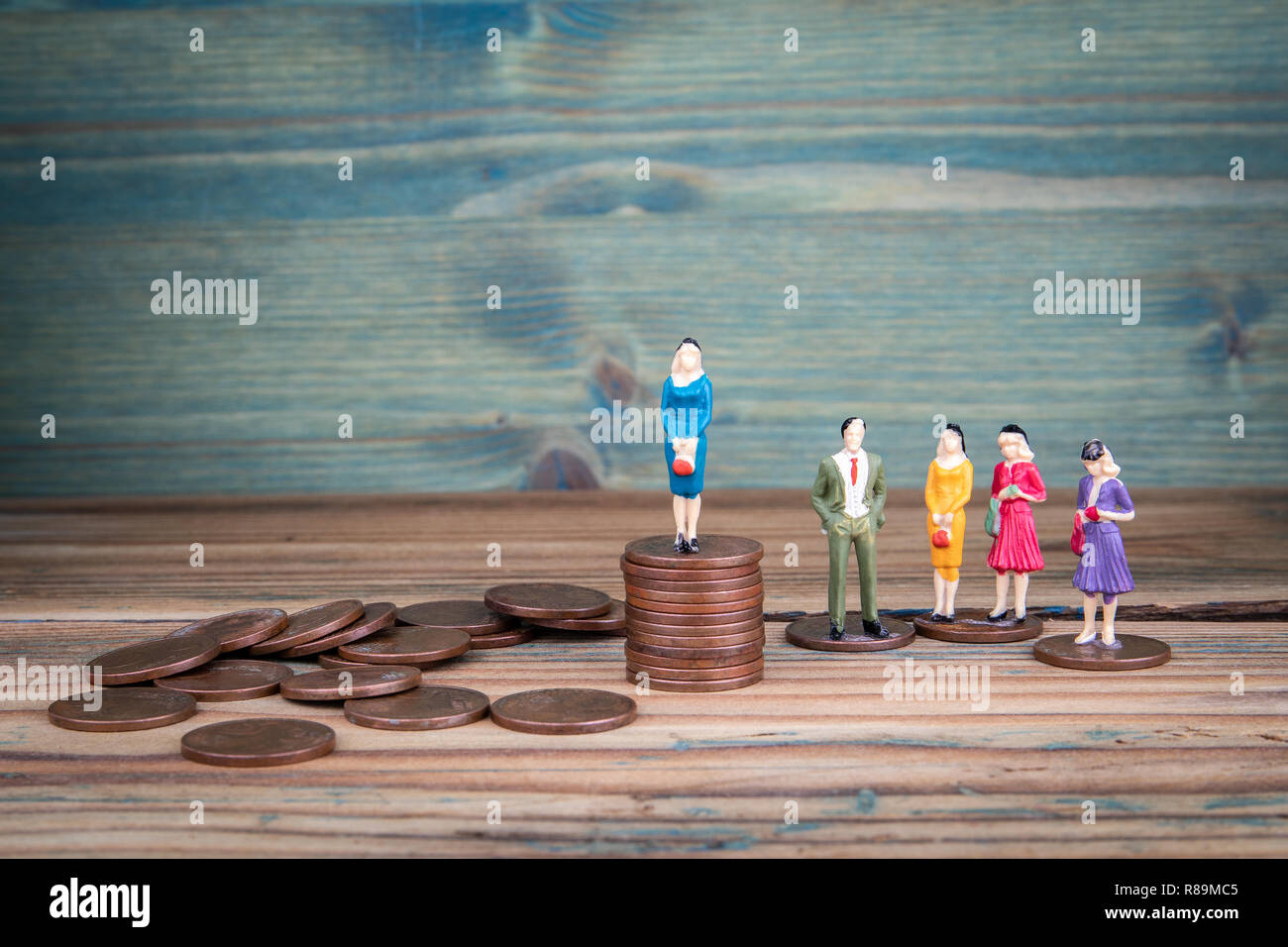 Miniature people standing on piles of coins Stock Photo - Alamy