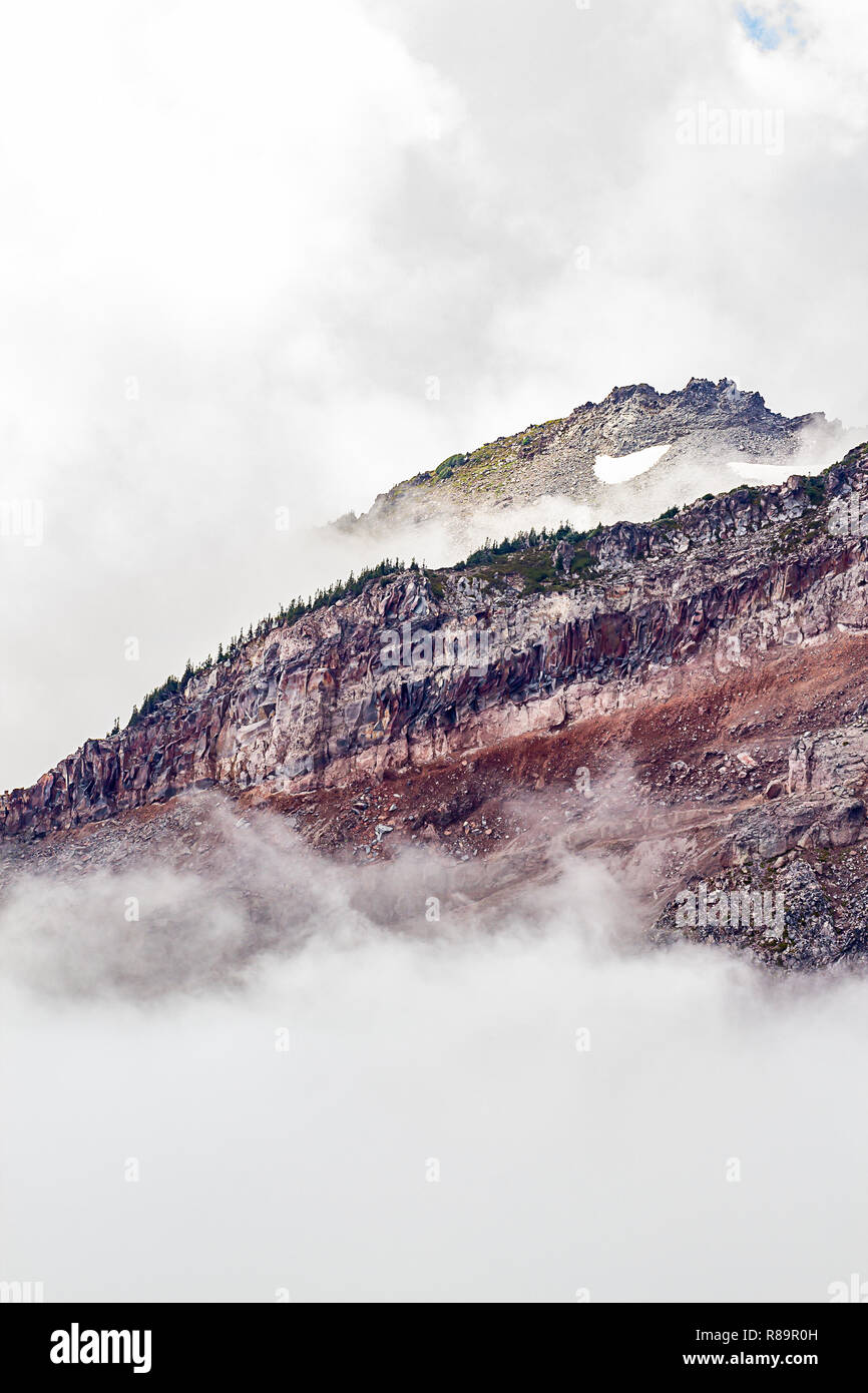 vertical abstract of colorful cliff sides in clouds and fog Stock Photo ...