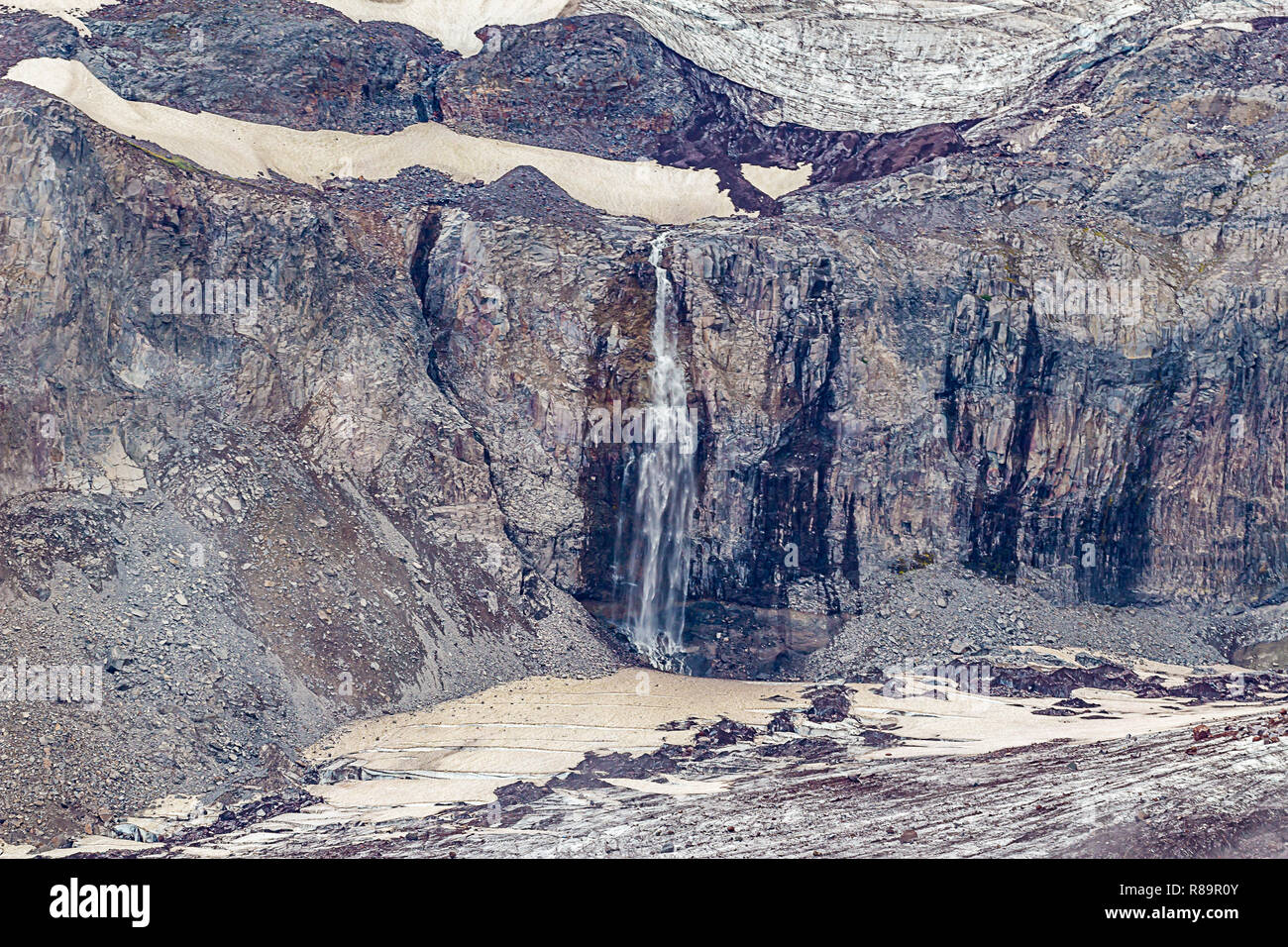 craggy cliff face with snow and ice melting into waterfall Stock Photo ...