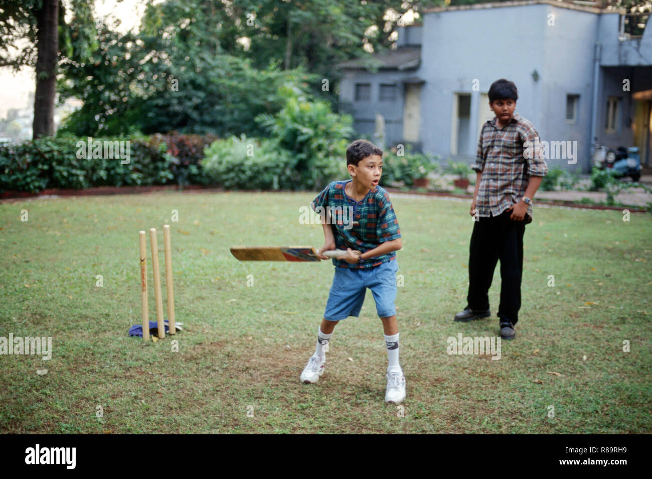Boys playing cricket in garden Stock Photo - Alamy