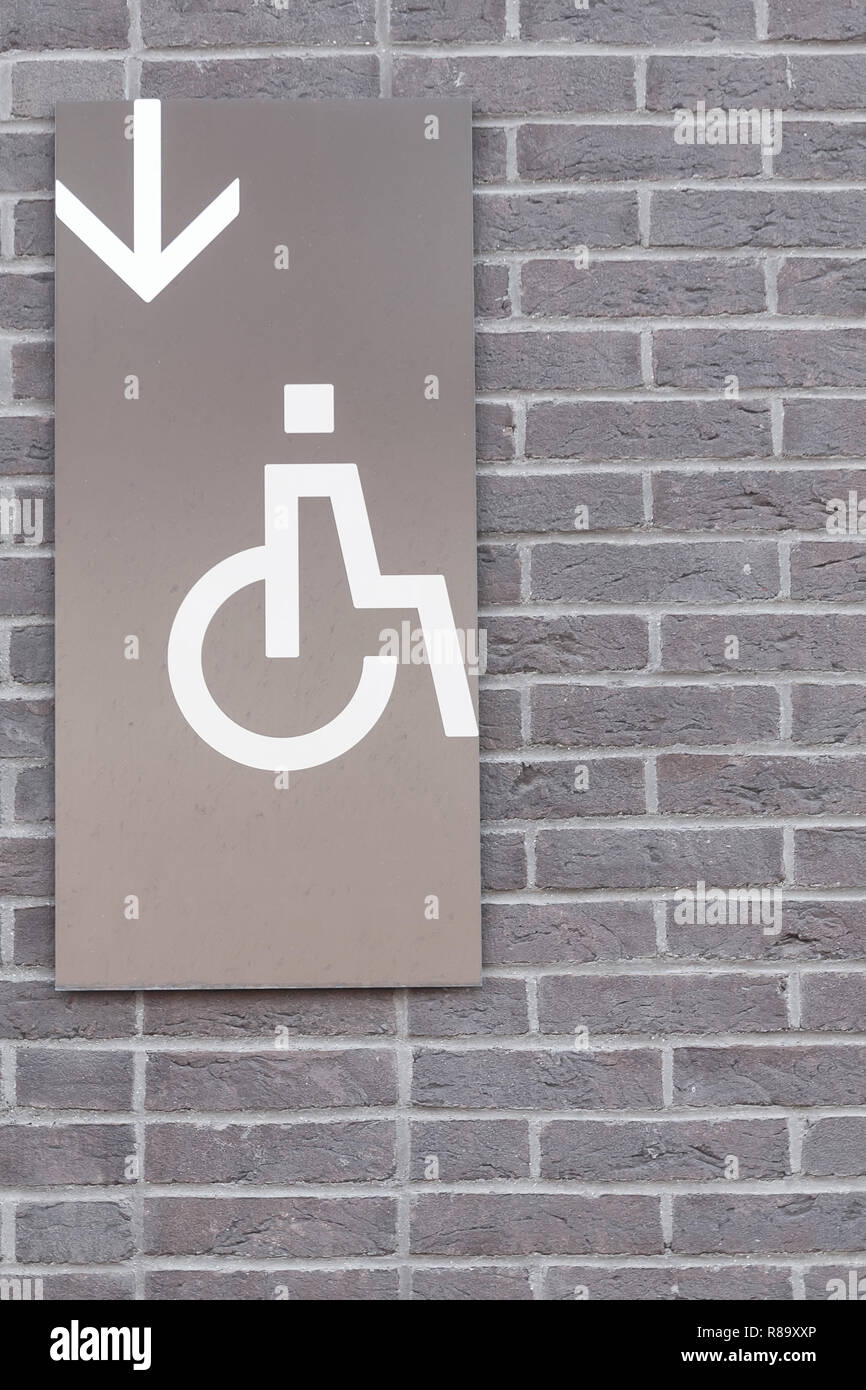 Conceptual abstract sign - disabled person and an arrow on a wall made ...