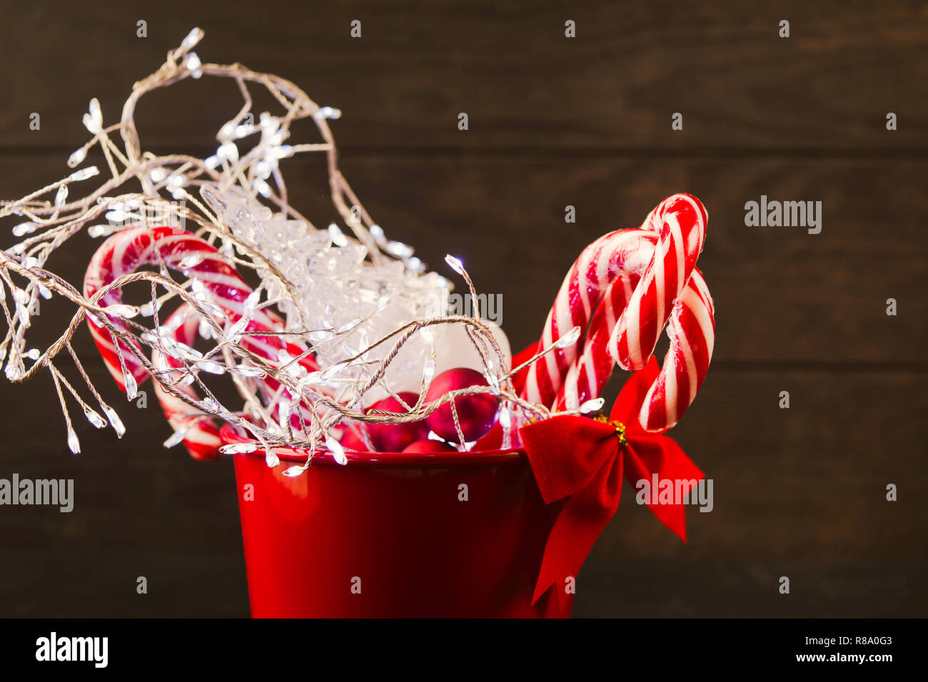 Red christmas bucket with decorations, candy canes and garland on ...
