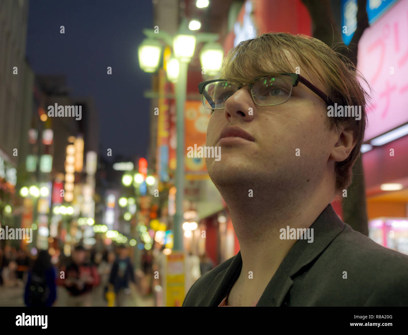 A young man exploring the neon lights of a big Asian city Stock Photo ...