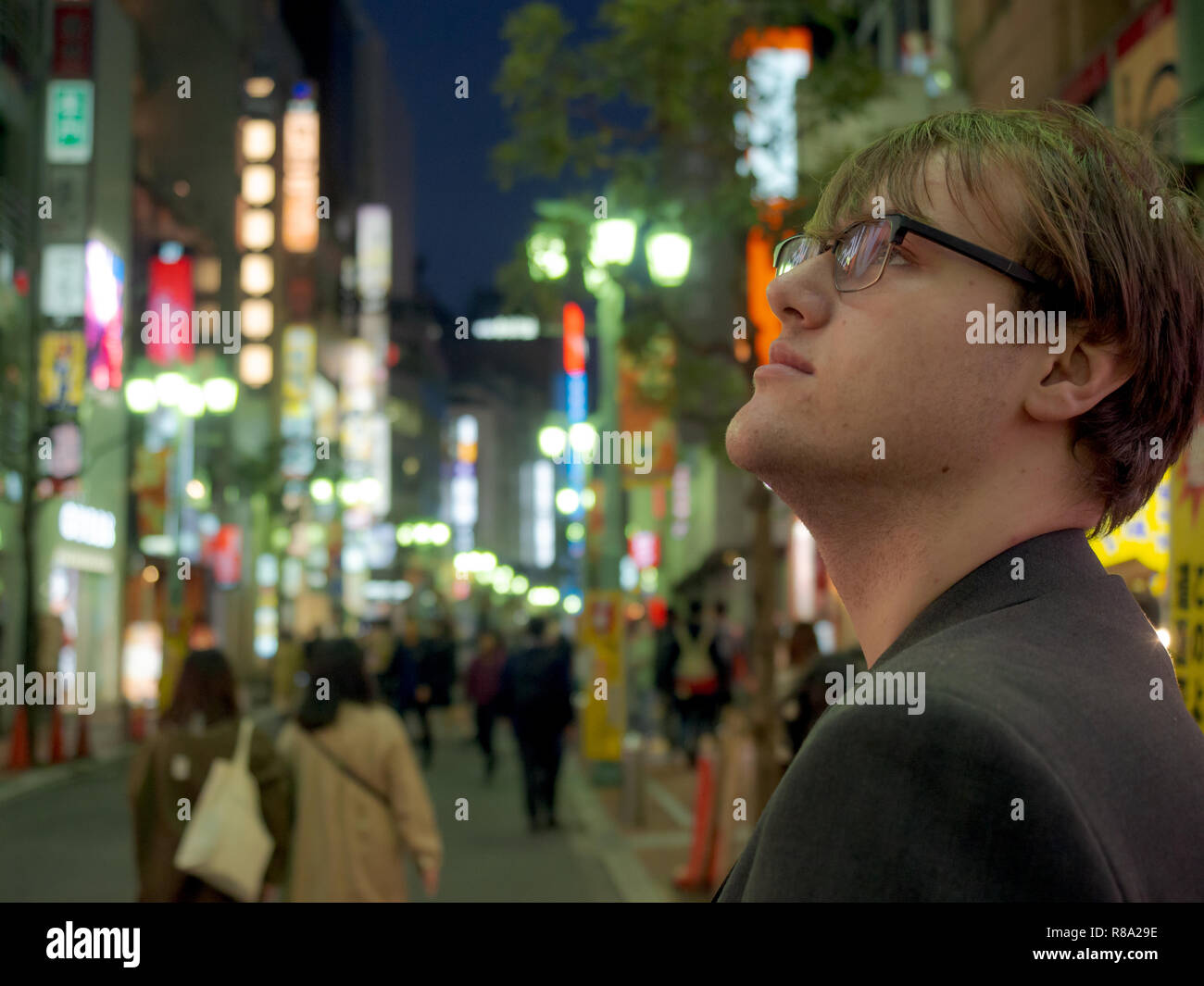 A young man exploring the neon lights of a big Asian city Stock Photo ...