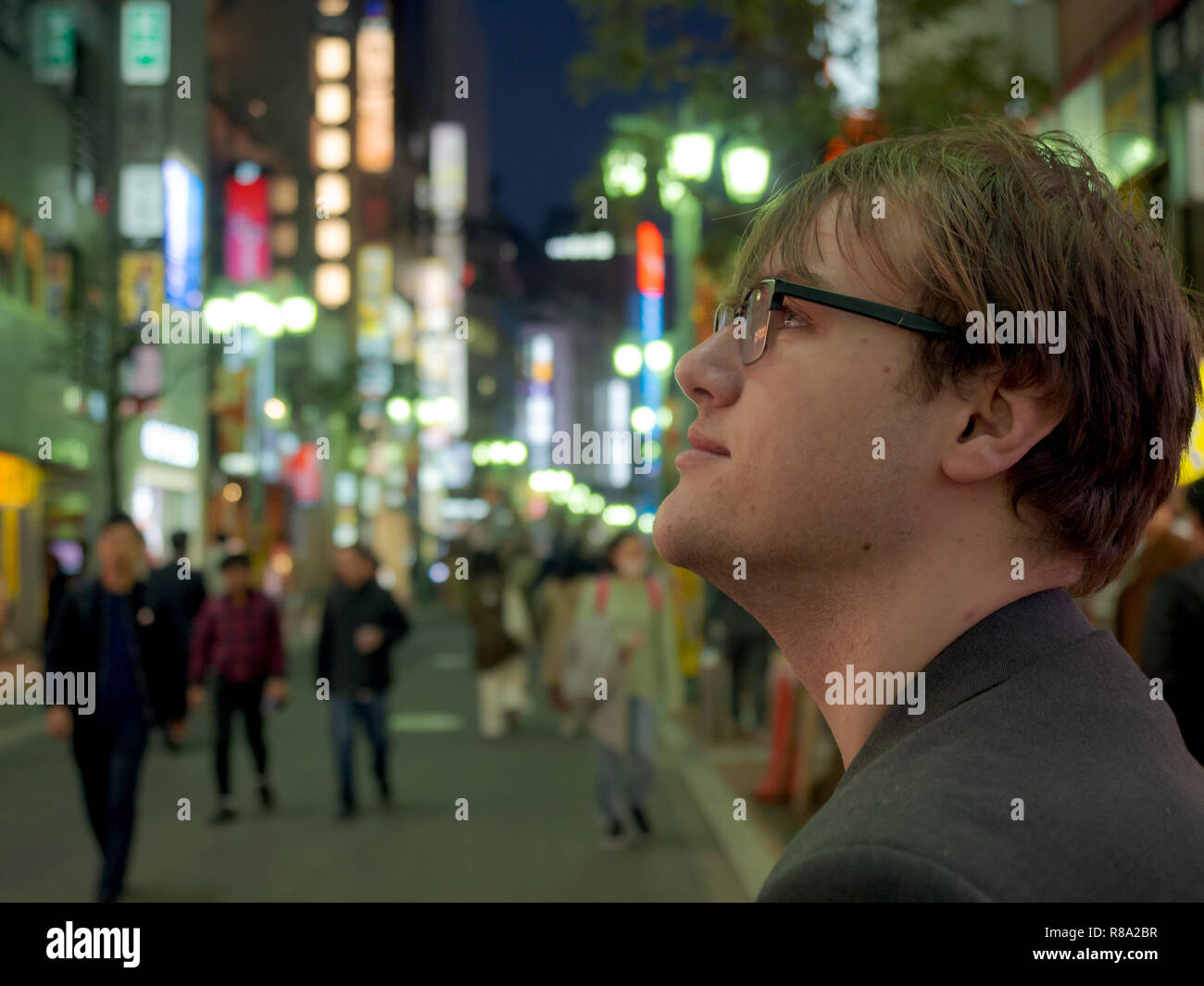 A young man exploring the neon lights of a big Asian city Stock Photo ...