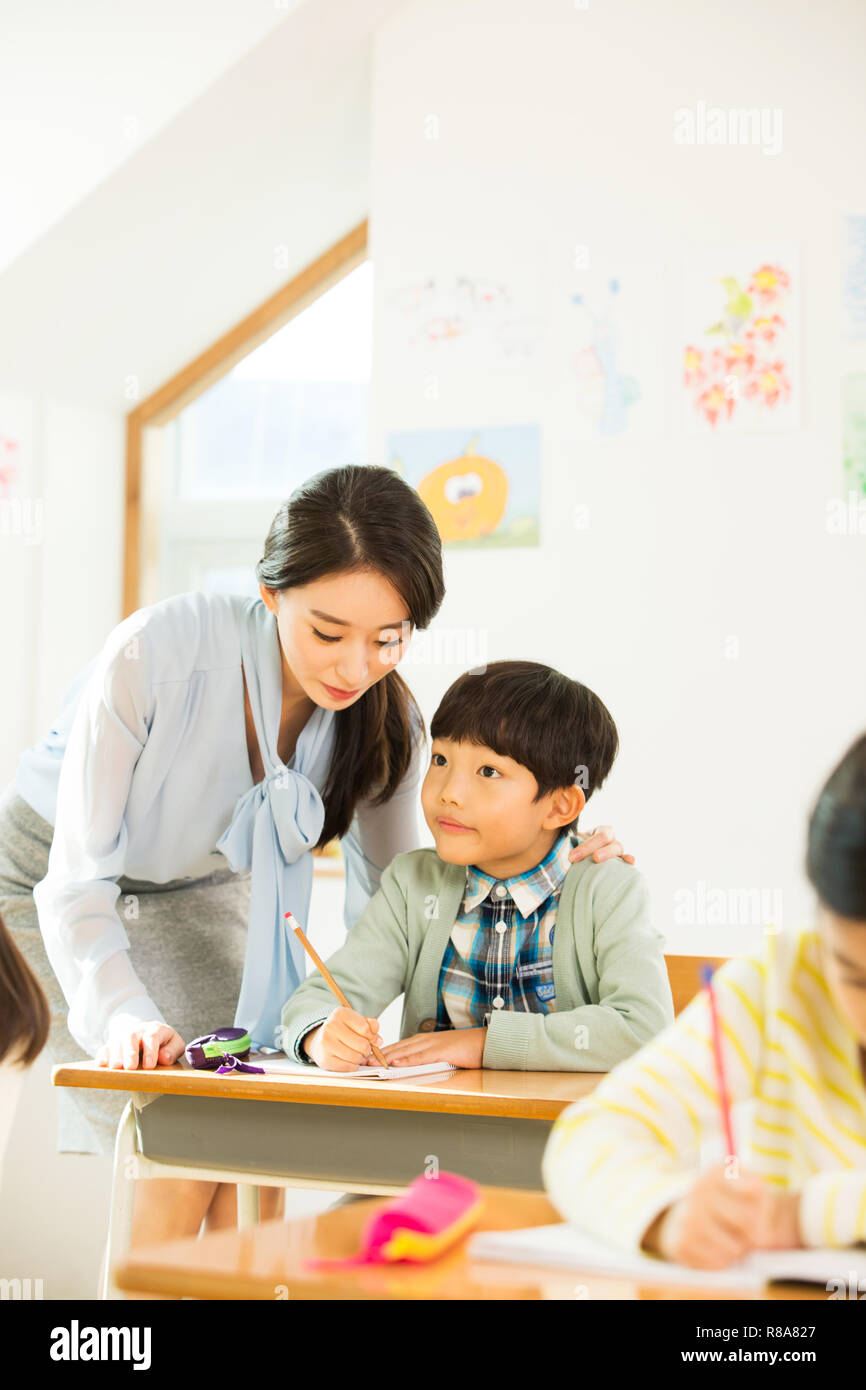 Female Teacher Assisting A Young Student Stock Photo - Alamy