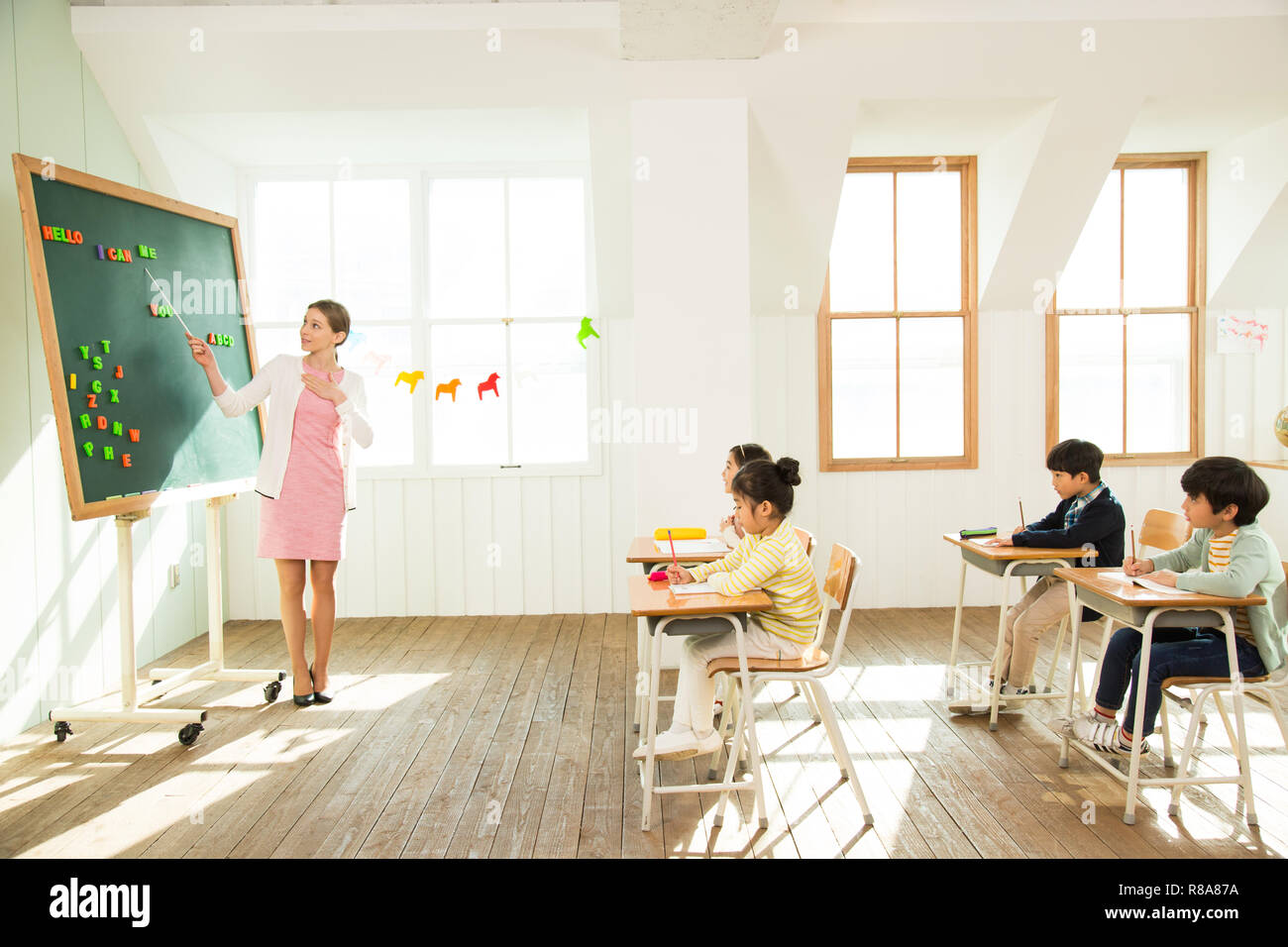 Female Teacher Teaching English To Young Students Stock Photo - Alamy