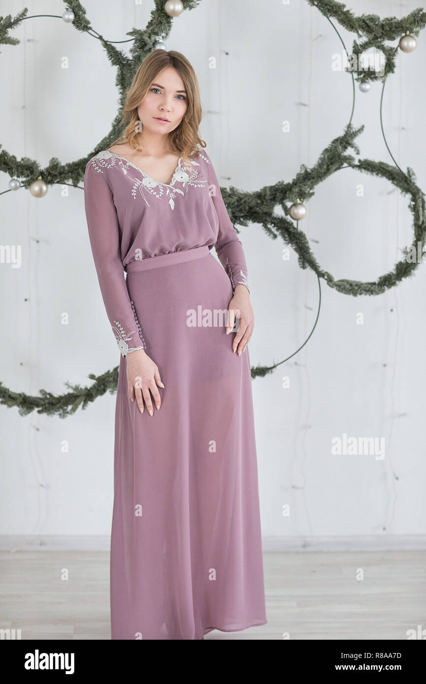 Young beautiful woman with hair of average length in an evening dress ...