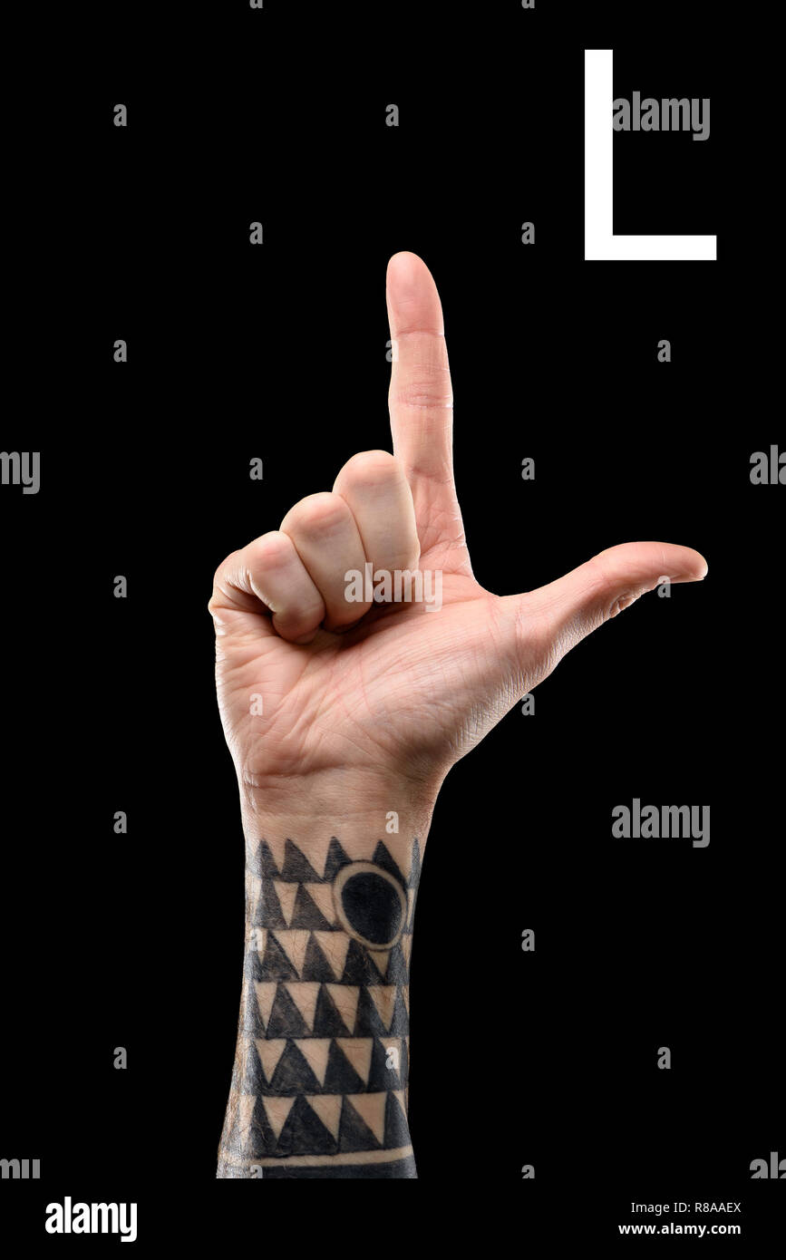 cropped view of tattooed hand showing latin letter - L, sign language ...