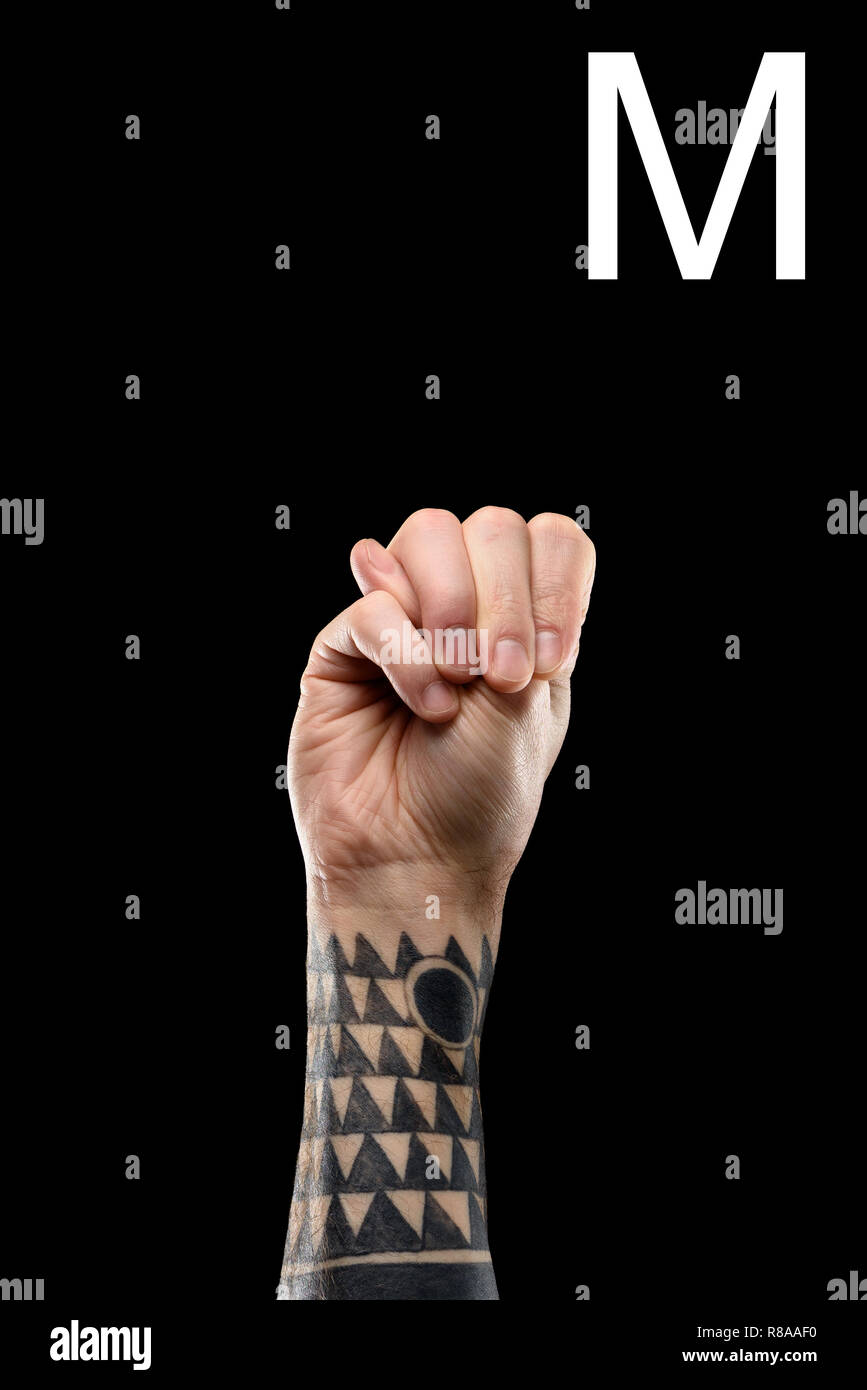 cropped view of tattooed hand showing latin letter - M, sign language ...