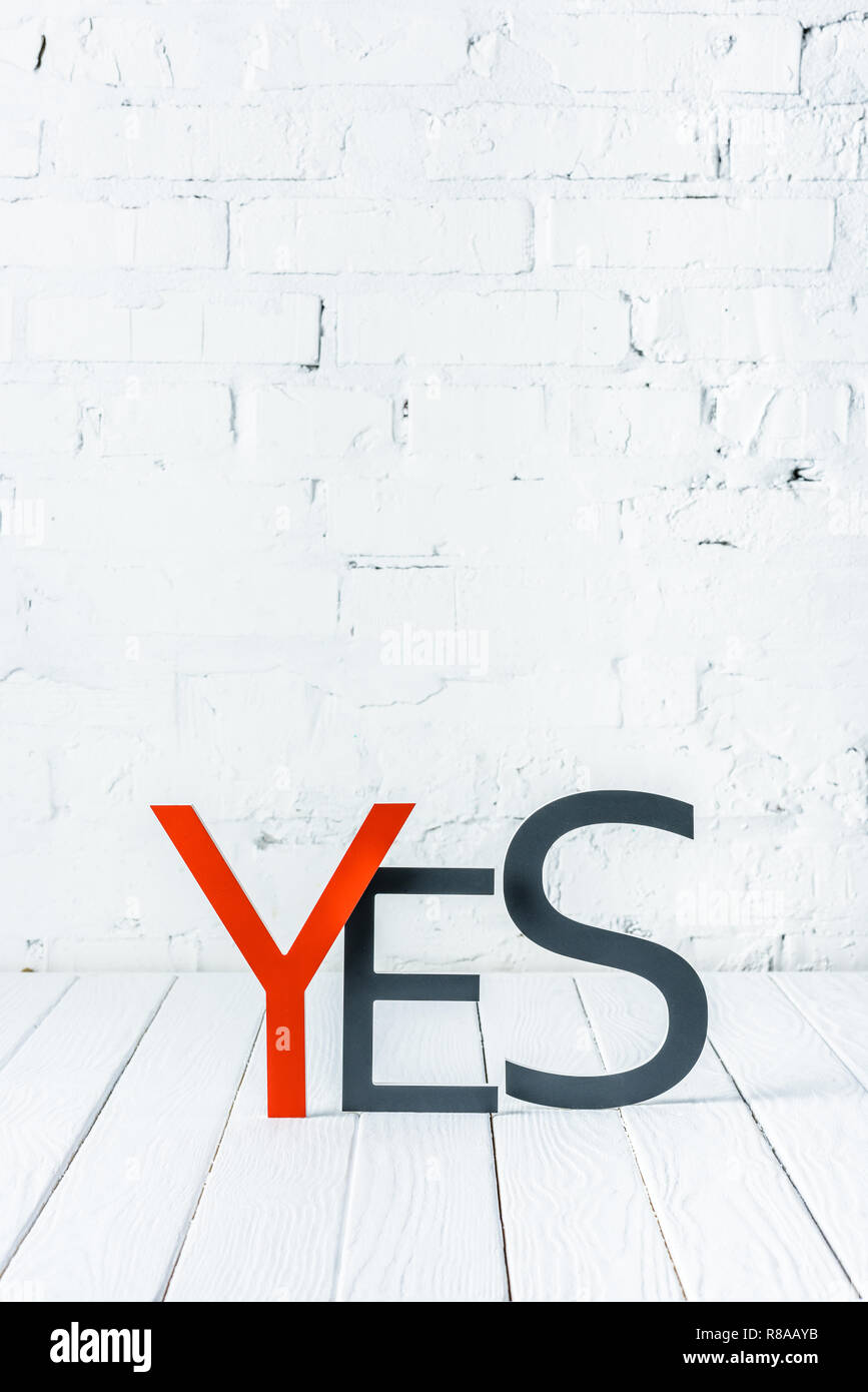 "yes" lettering with decorative red and black letters on wooden surface ...
