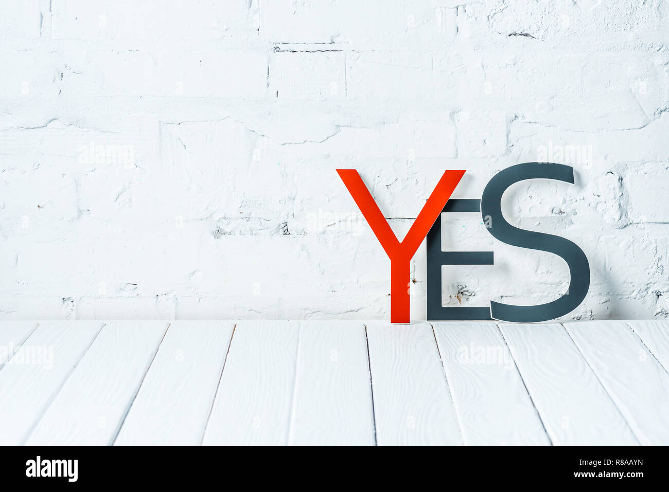 "yes" lettering with decorative red and black letters on wooden table ...