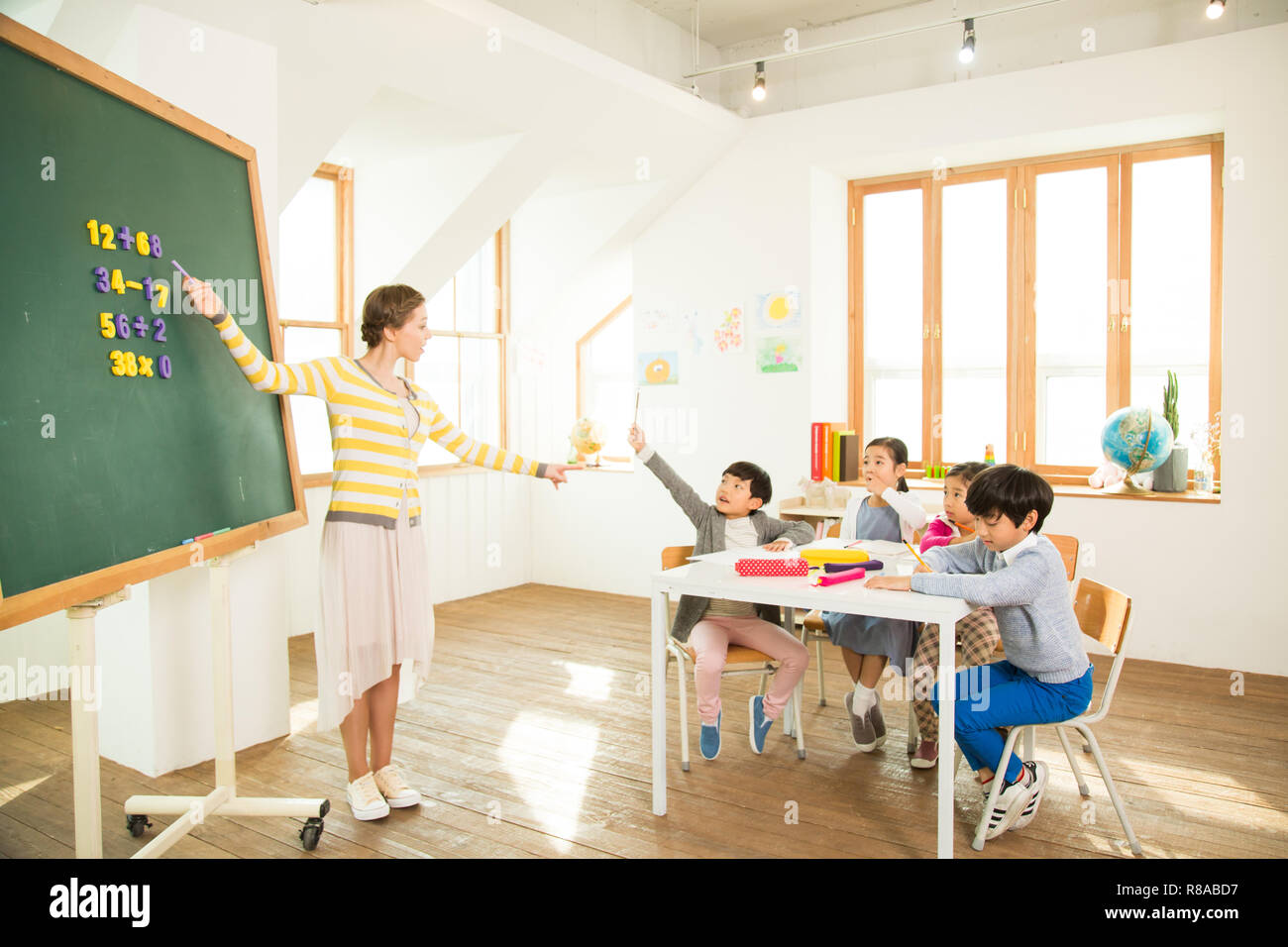 Young Students Learning With A Foreign Female Teacher Stock Photo - Alamy