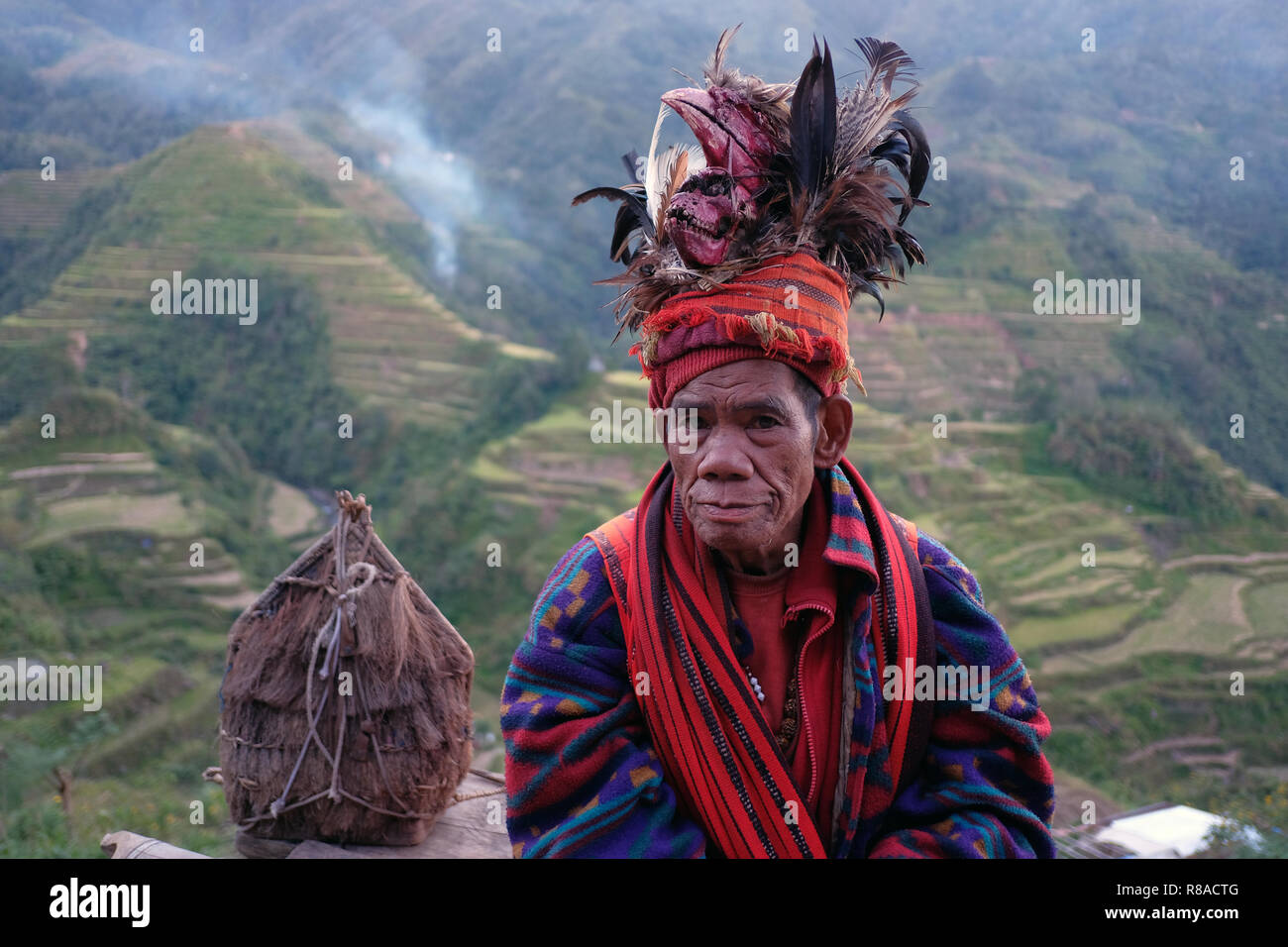 An elderly Ifugao man wearing headdress adorned with feathers and ...