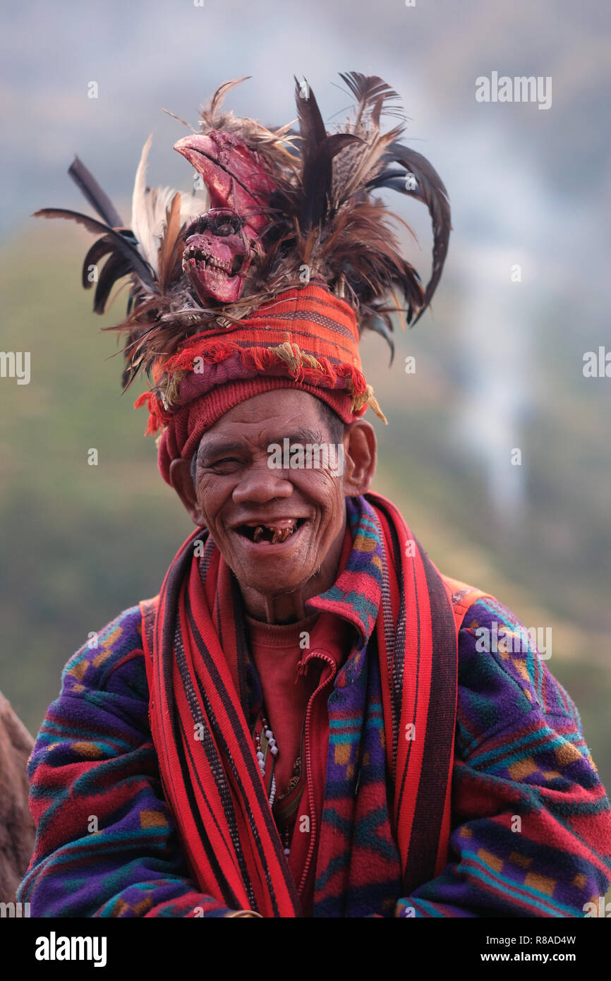 An elderly Ifugao man wearing headdress adorned with feathers and ...