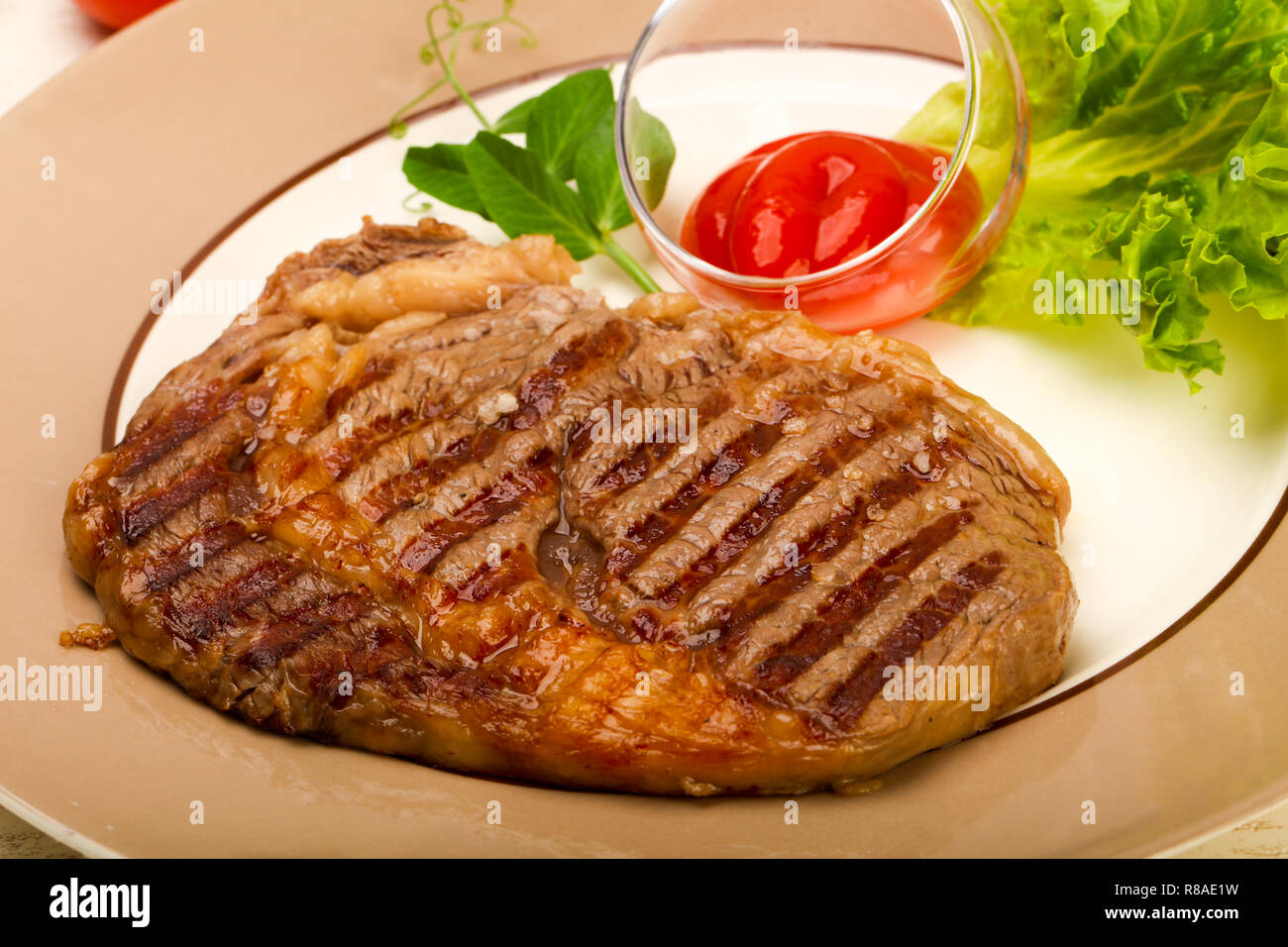 Grilled Rib eye steak with sauce Stock Photo - Alamy