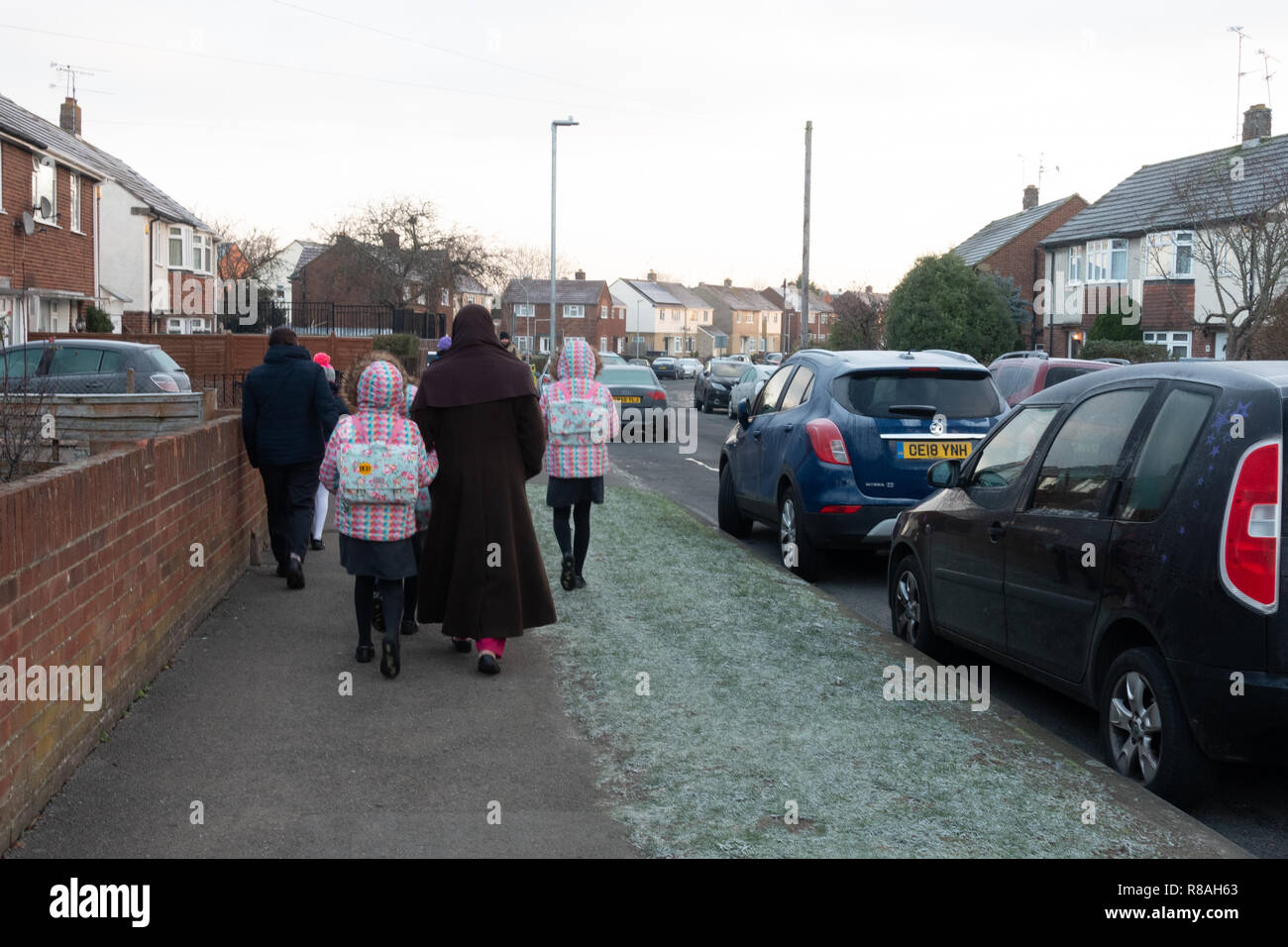 Children and parents walk to school on a cold, frost morning. People ...