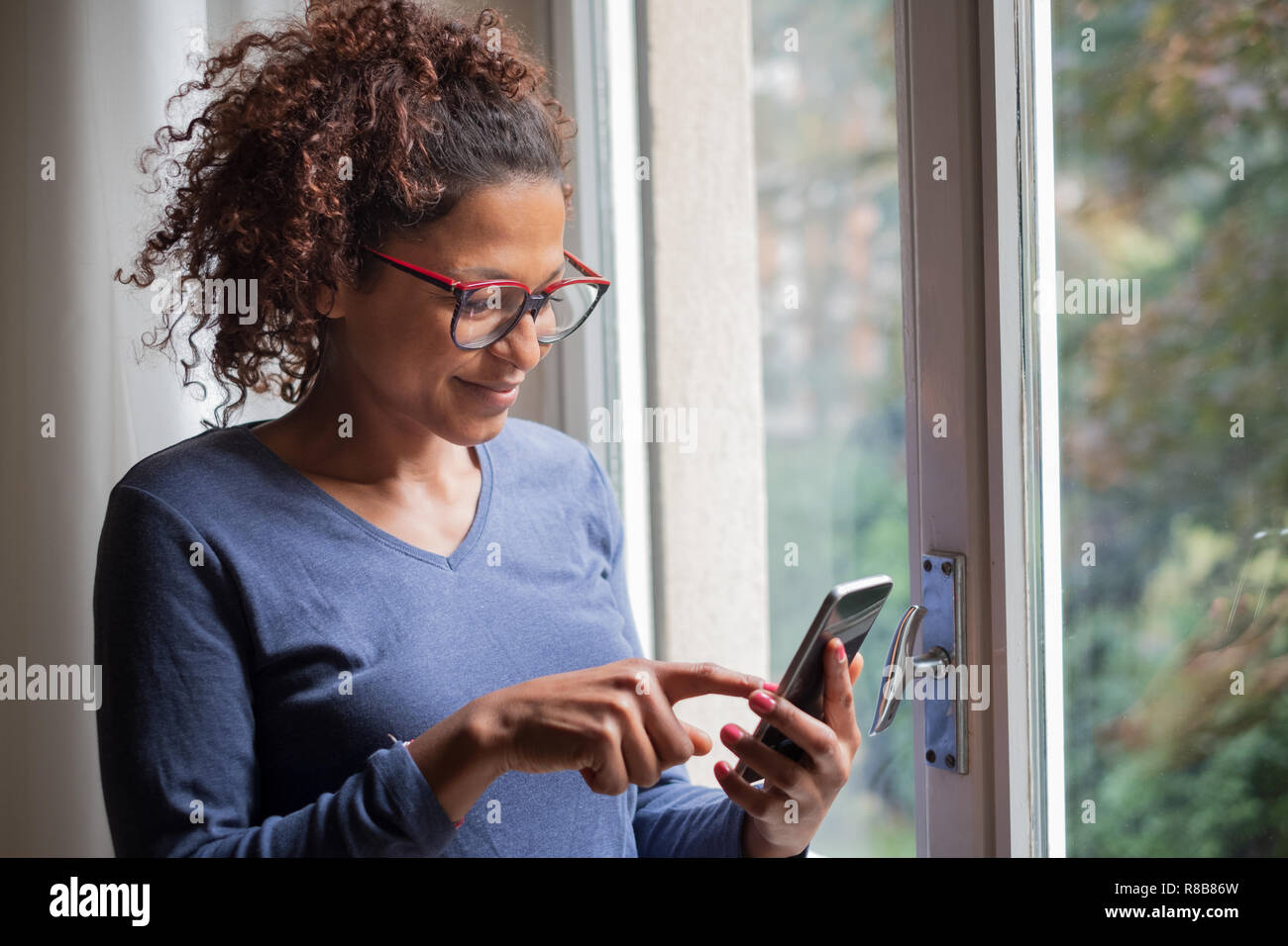 Woman standing beside window hi-res stock photography and images - Alamy